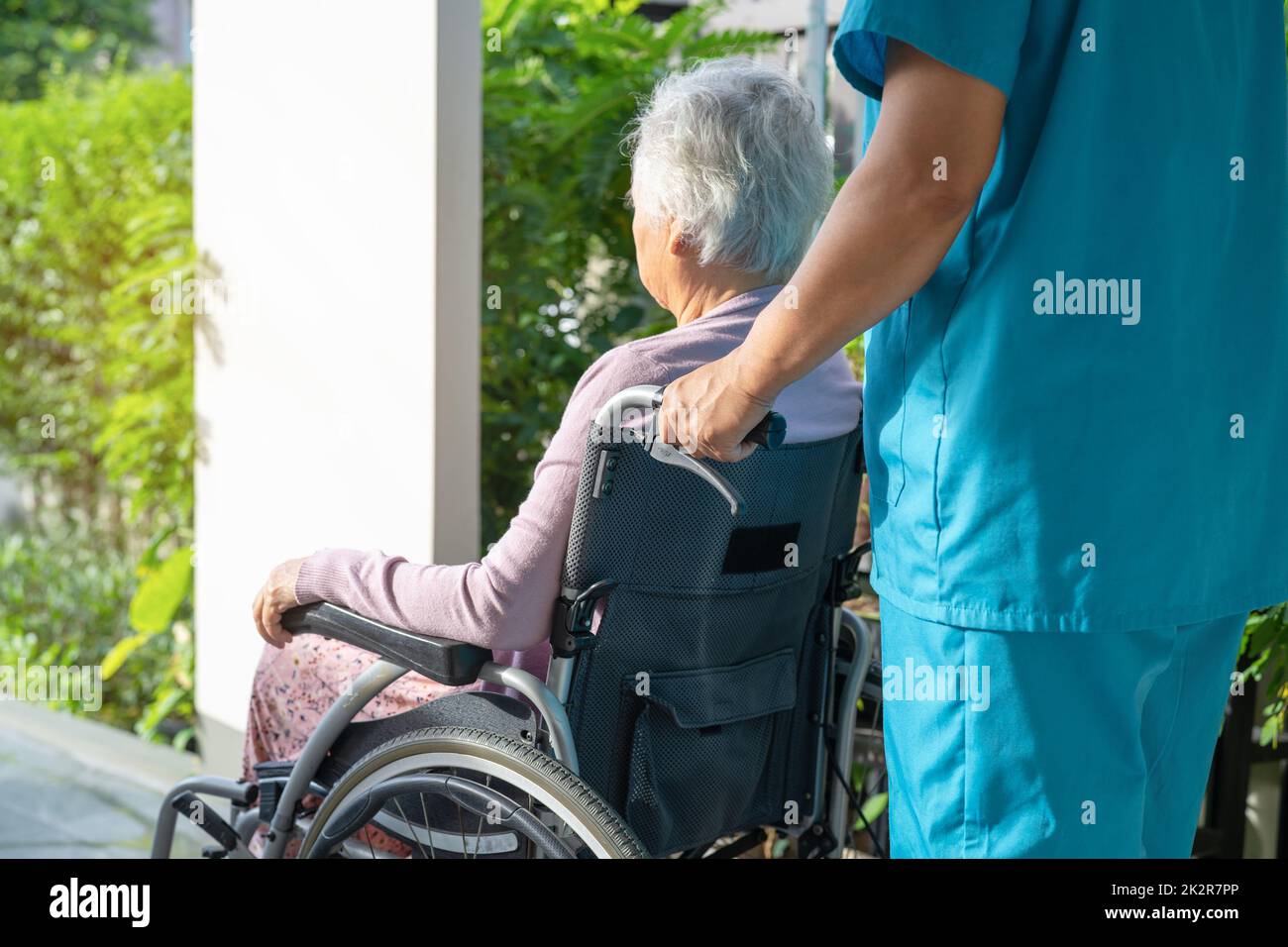 Caregiver help and care Asian senior or elderly old lady woman patient sitting in wheelchair on ...