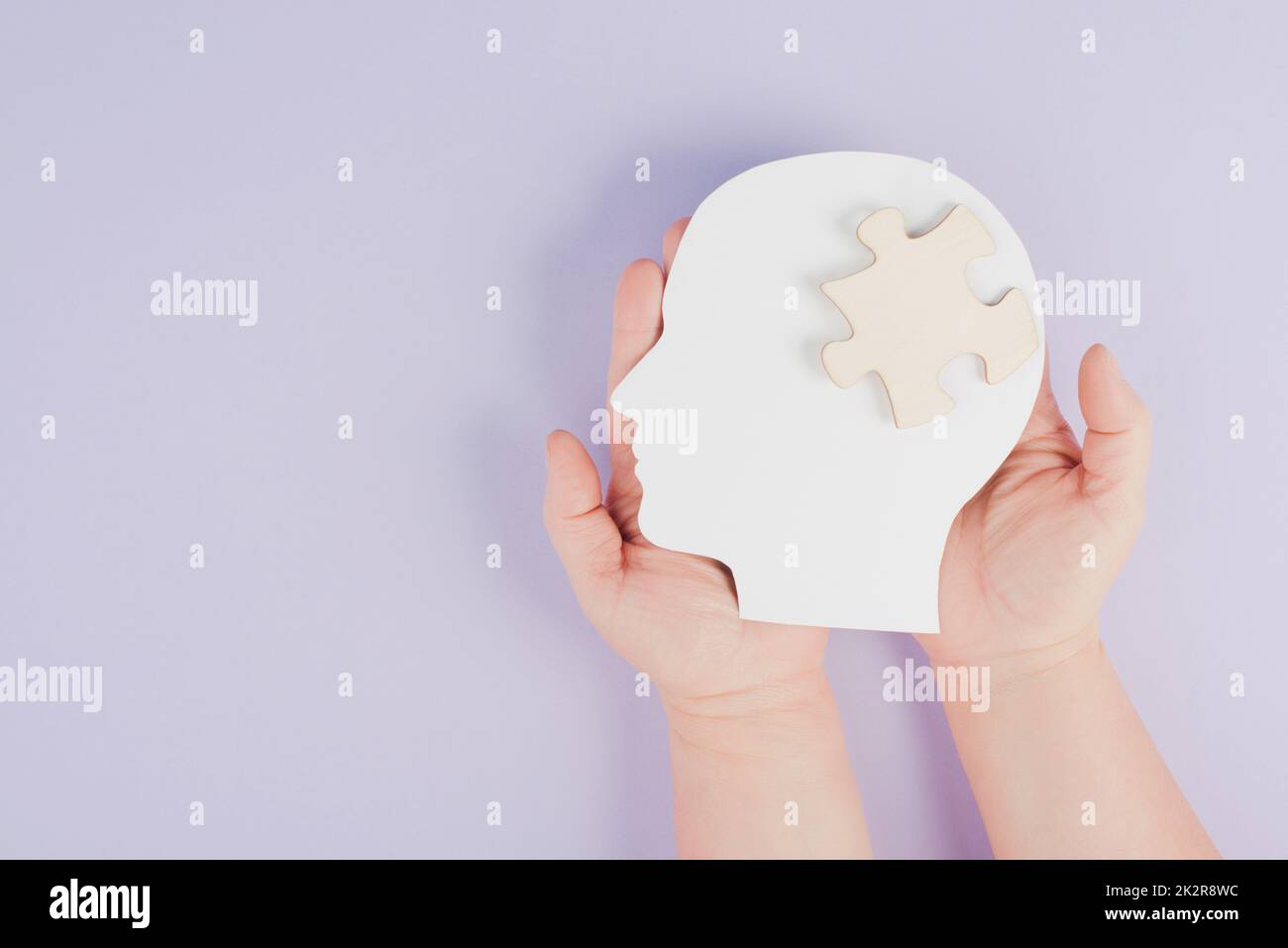 Holding a head with a puzzle piece, mental disease like Autism ...