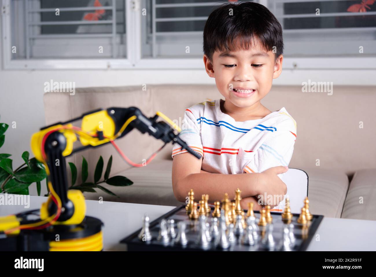 Asian little boy is playing chess with robot machine arm Stock Photo ...