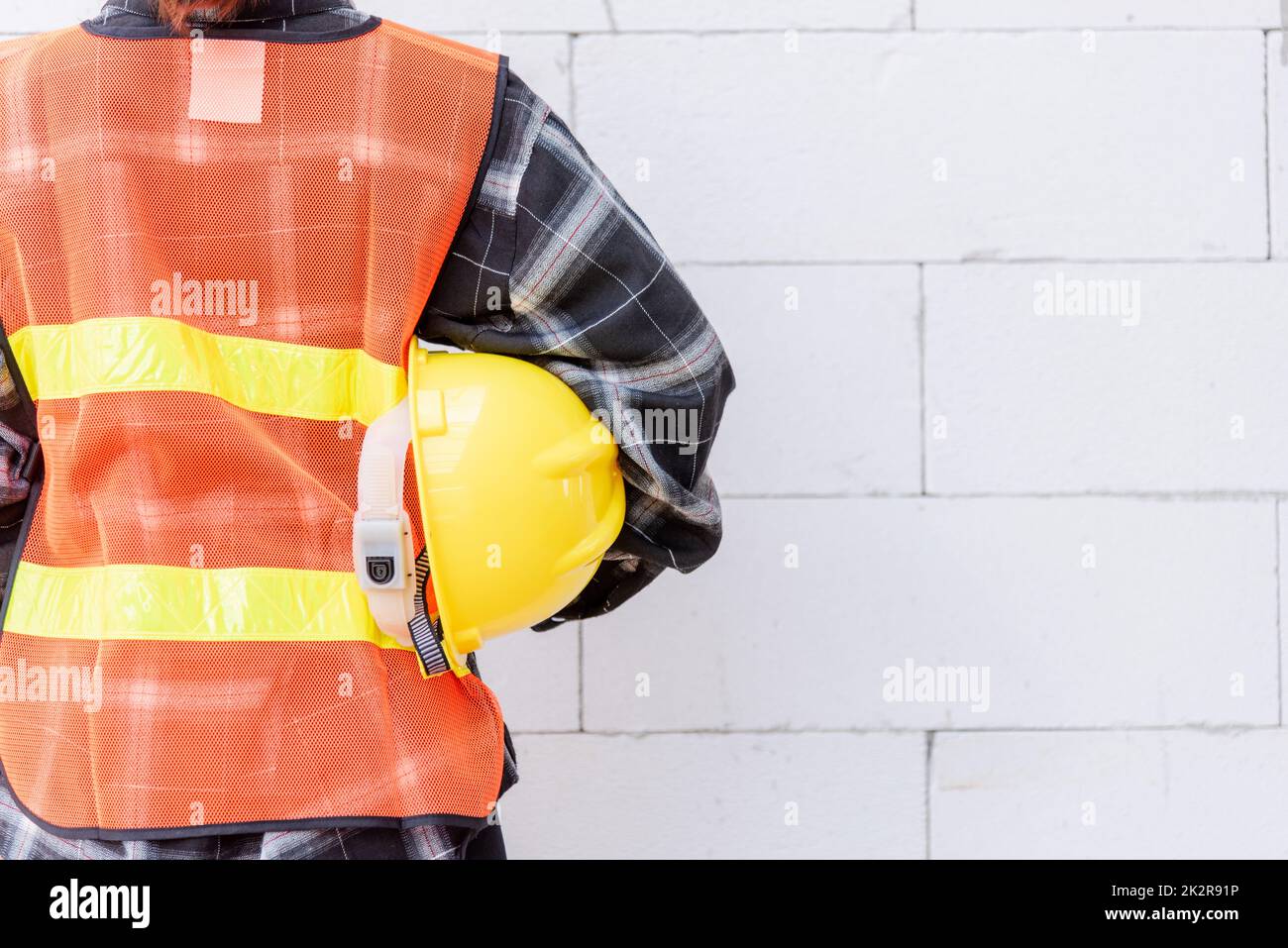 Back view of engineer, architect, supervisor worker wear reflective clothing for the safety of ...