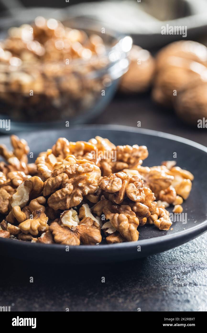 Peeled walnut kernels on plate on black table Stock Photo - Alamy