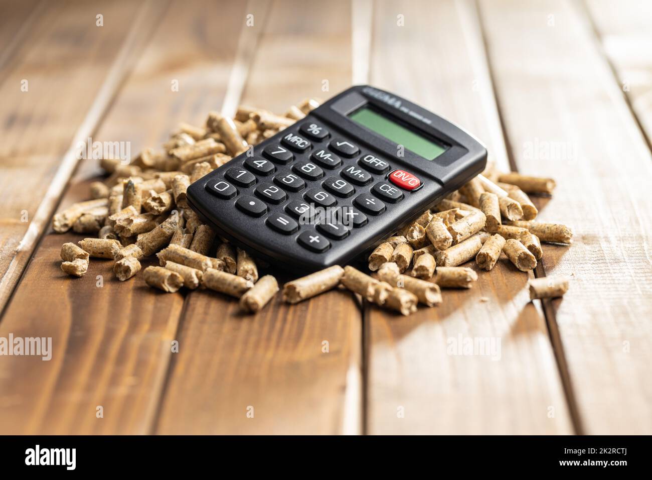 Wooden pellets and calculator, biofuel on wooden table. Ecologic fuel ...