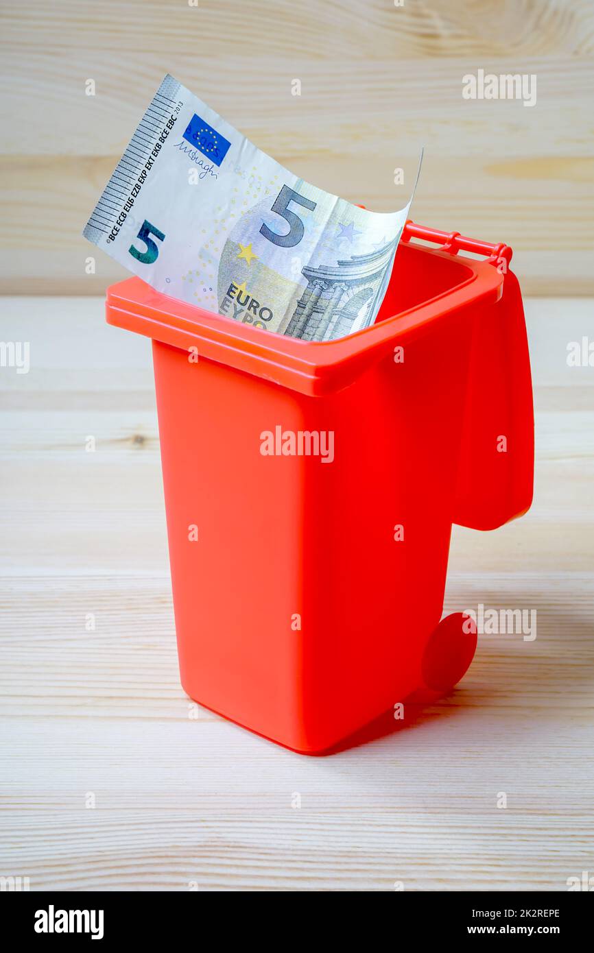 Euro banknote in a garbage can as a symbol for garbage fees, waste of ...