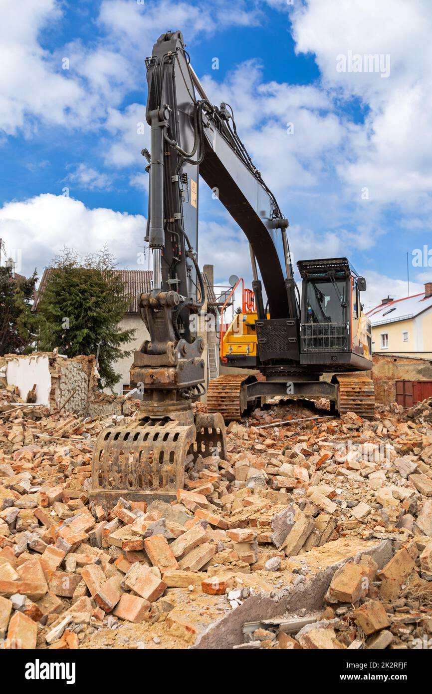 Excavator on debris of a demolished building in Germany Stock Photo - Alamy