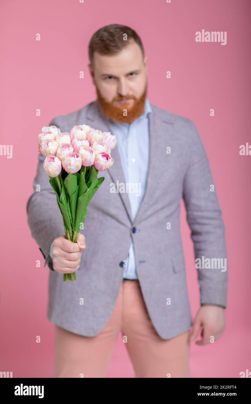 Handsome man holding bouquet of tulips Stock Photo - Alamy