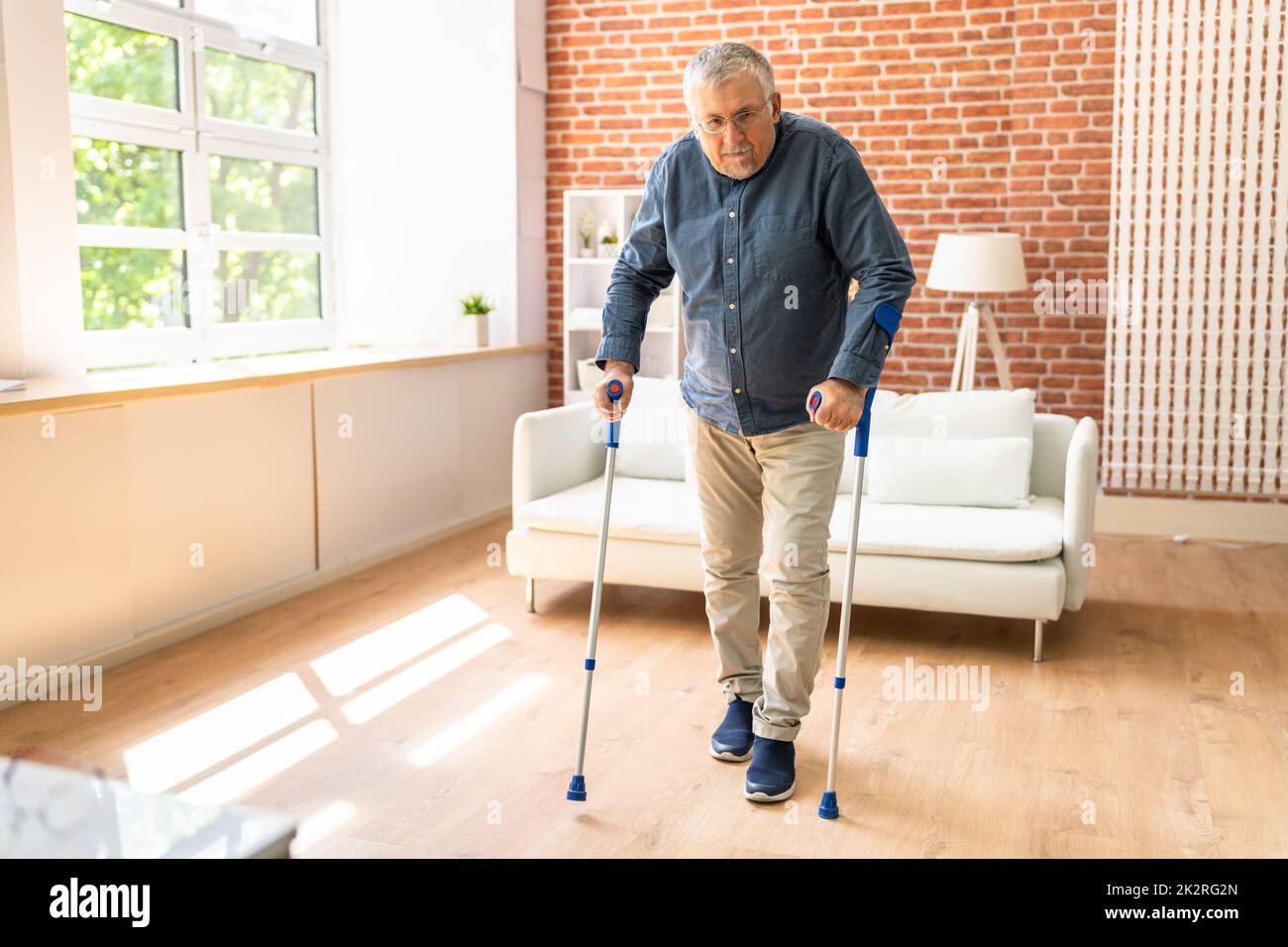 Man Walking With Crutches Stock Photo - Alamy