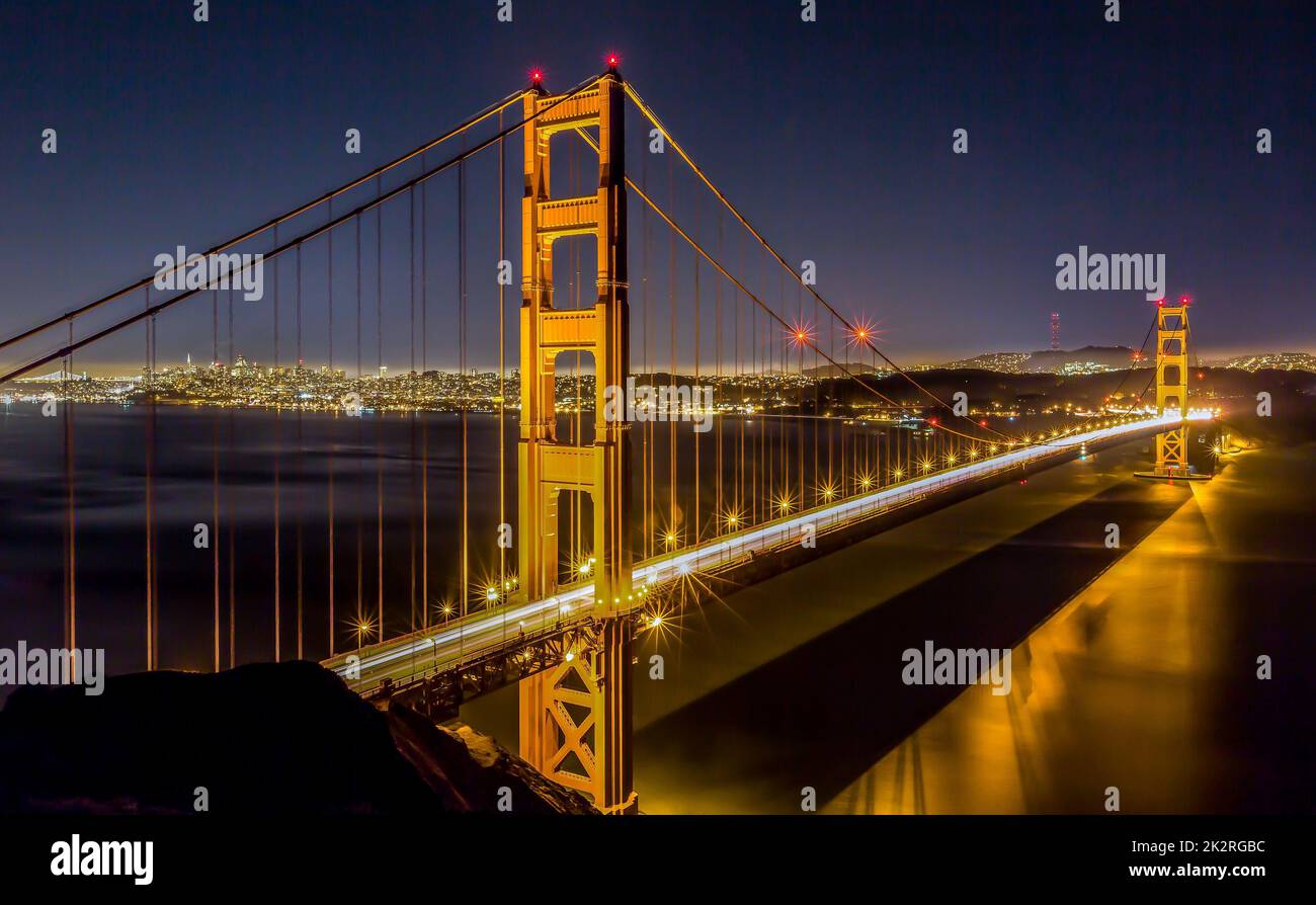 A beautiful view of the Golden Gate Bridge at night with bright yellow ...