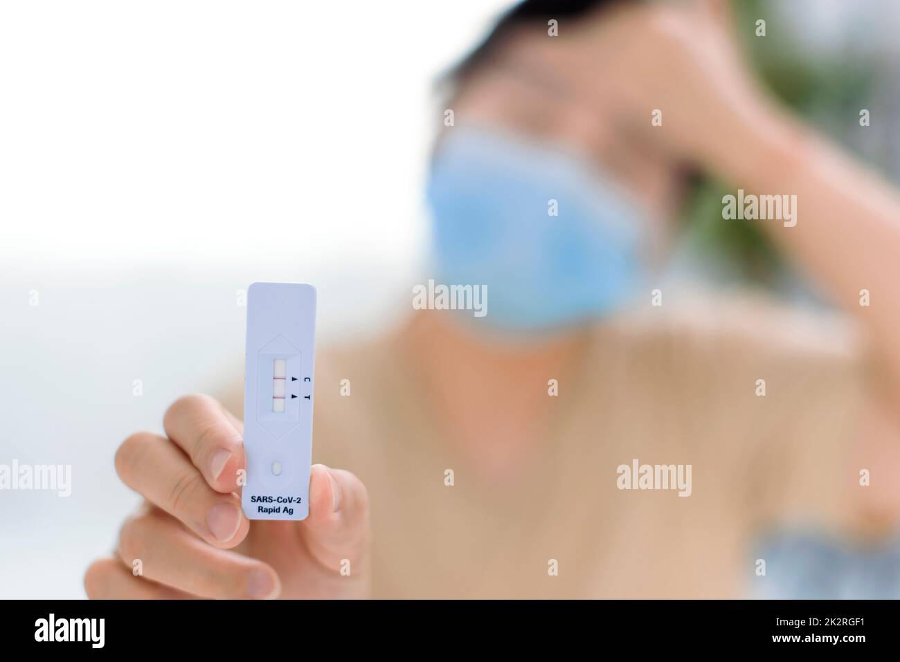 woman holding Rapid Antigen Test kit with Positive result during swab ...