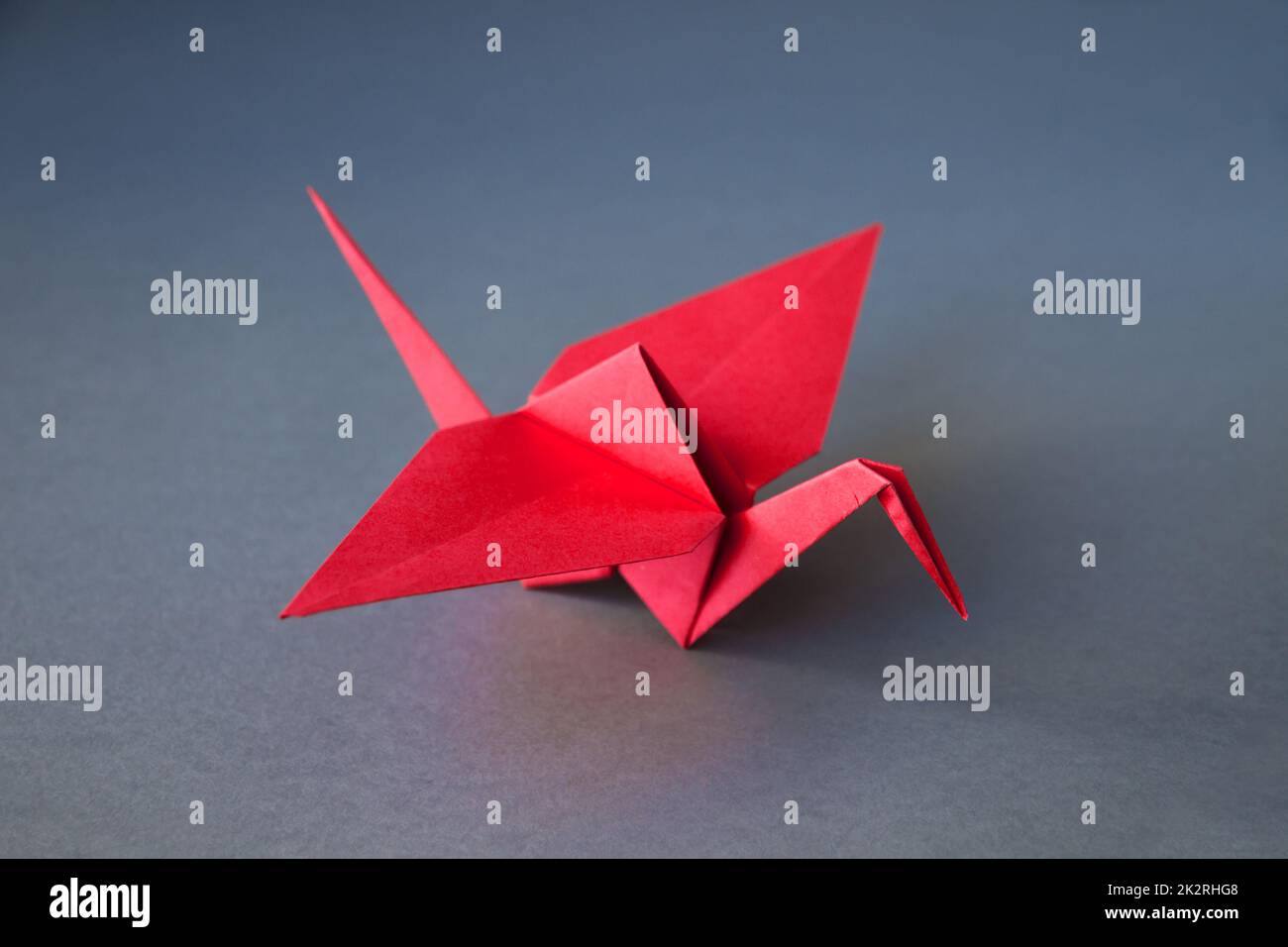 Red paper crane origami isolated on a grey background Stock Photo - Alamy