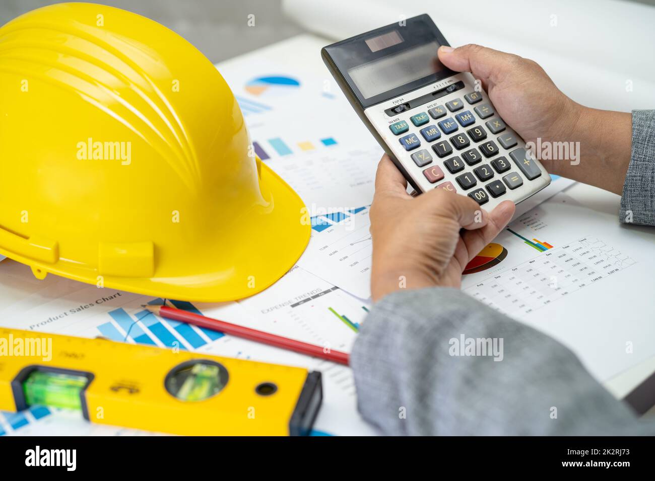 Asian engineer with architectural house plan project blueprint, graph ...