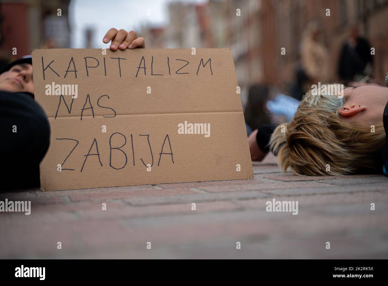 An activist lays on the ground while holding a placard during the ...