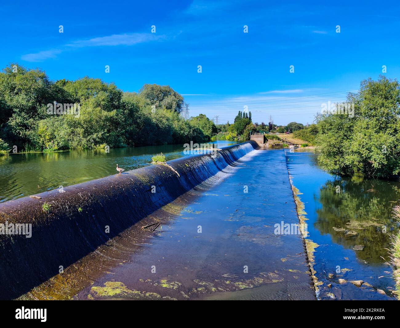 A pavement next to a beautiful natural scenery with a lake surrounded ...