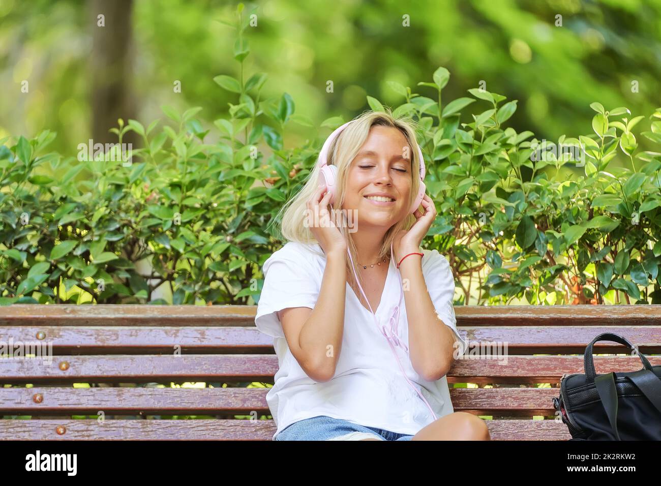Young woman with her eyes closed relaxing while listening to music with ...