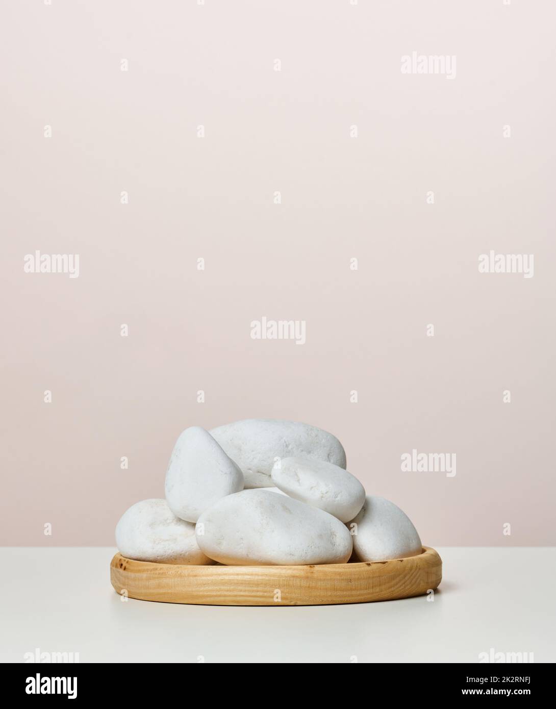A pile of round white stones on a wooden stand, a stage for displaying ...