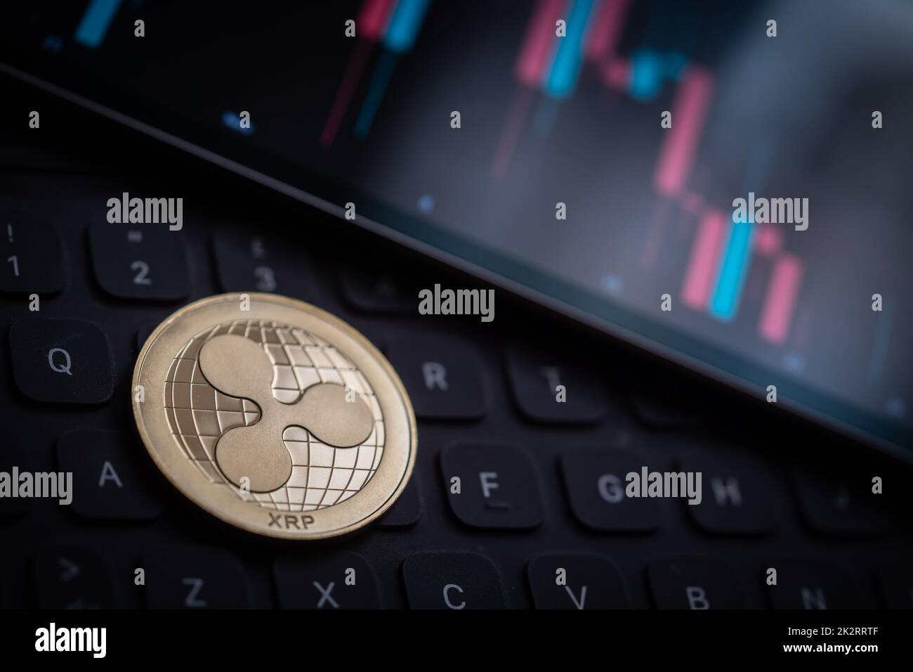Ripple cryptocurrency coin with candle stick graph chart, laptop ...
