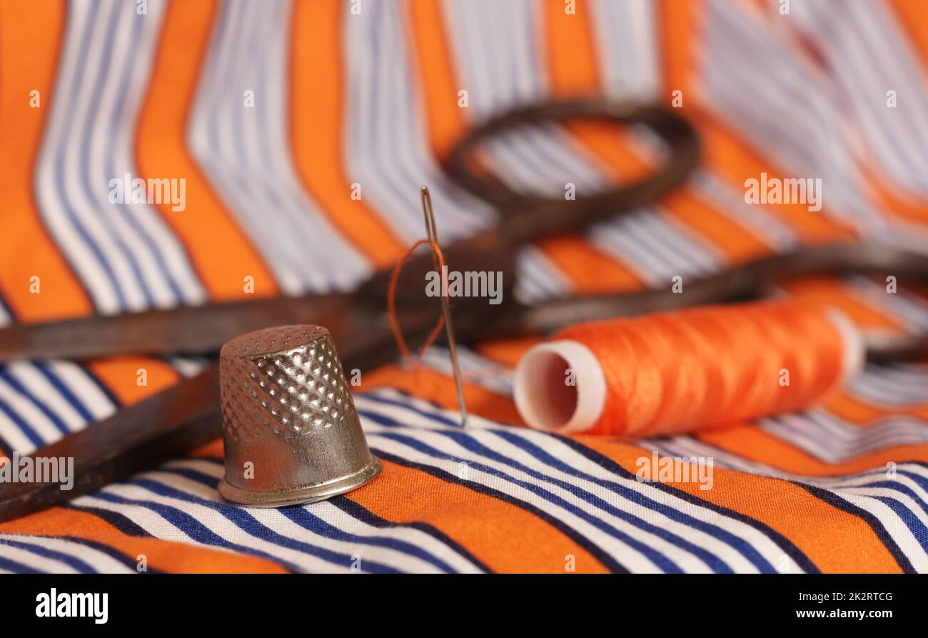Orange Thread and Thimble on Orange and White Striped Fabric Stock ...