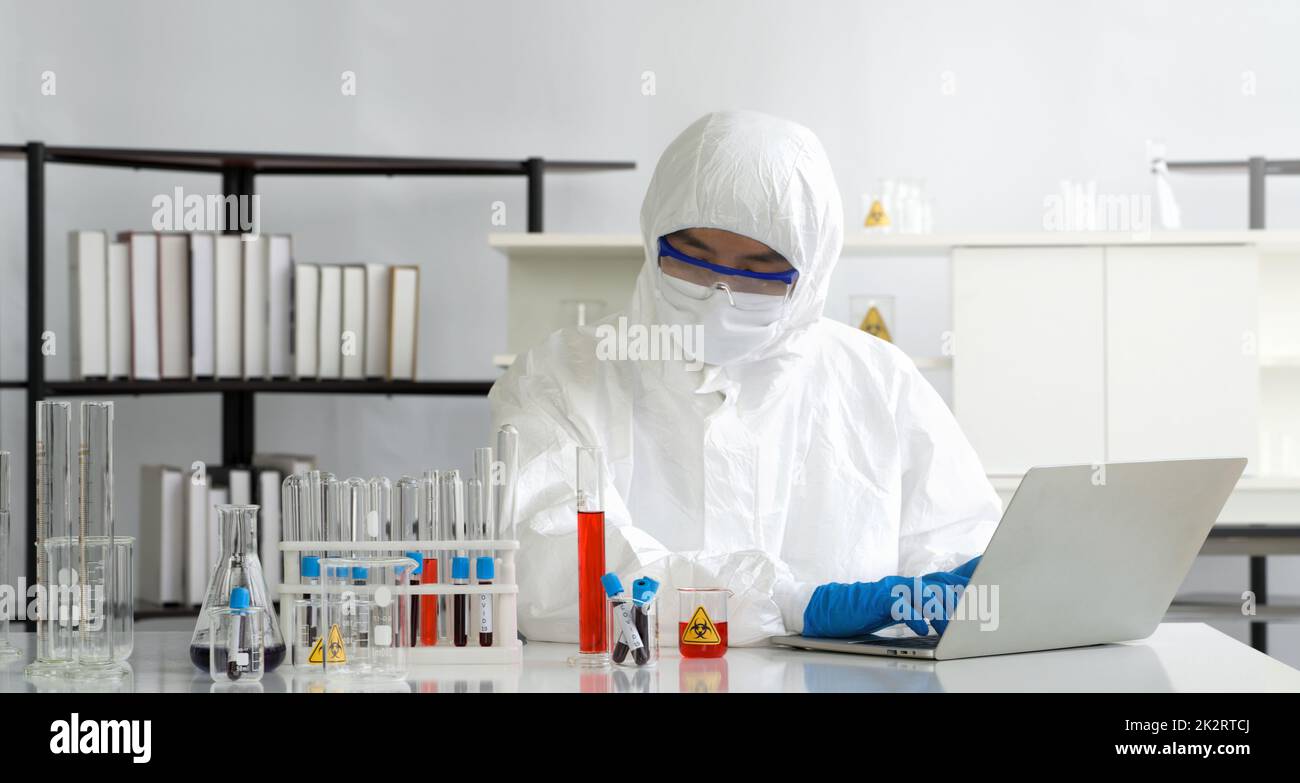 Epidemiological researcher in virus protective cloth looking at red ...