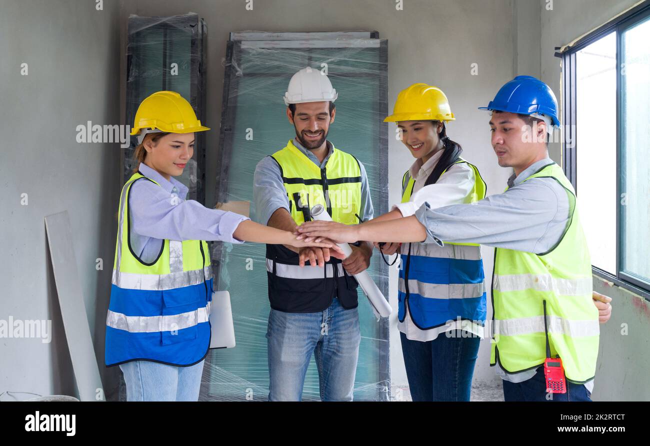 Caucasian architect with floor plan join hands with colleague after ...