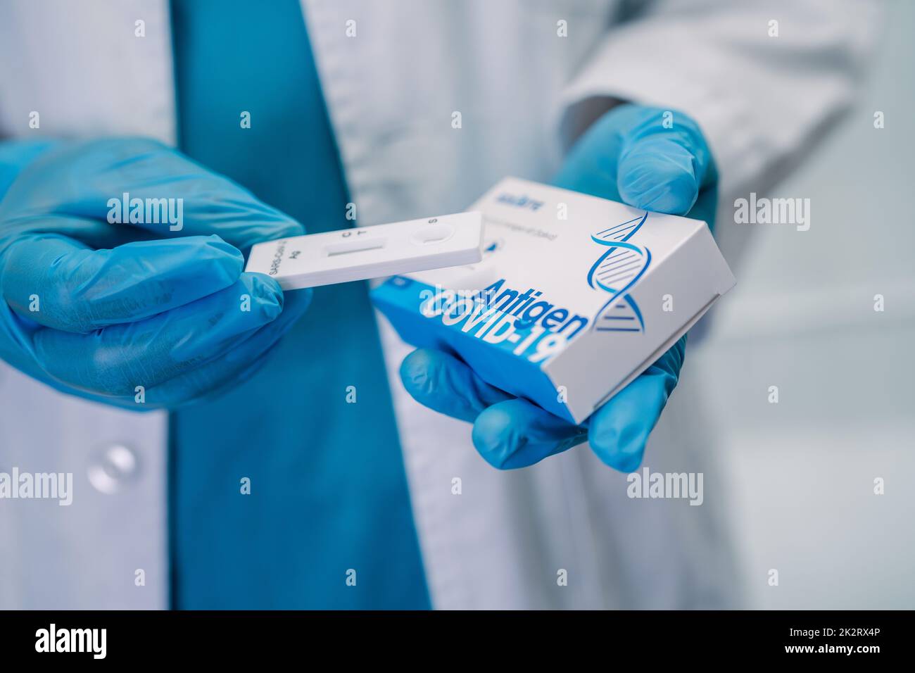 Asian doctor in PPE suit holding Saliva Antigen Test Kit for check ...