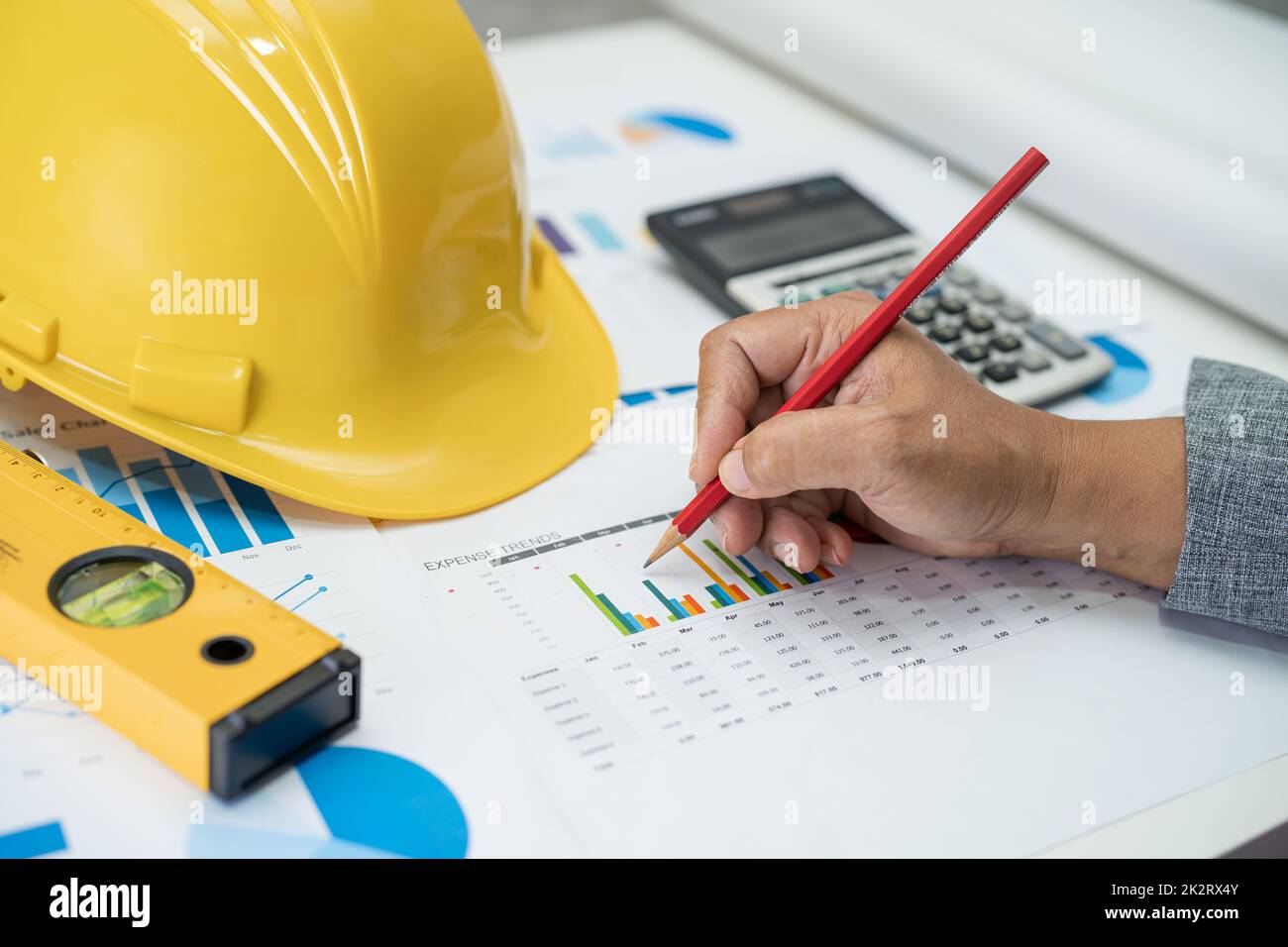 Asian engineer with plan project blueprint, graph and yellow helmet and ...