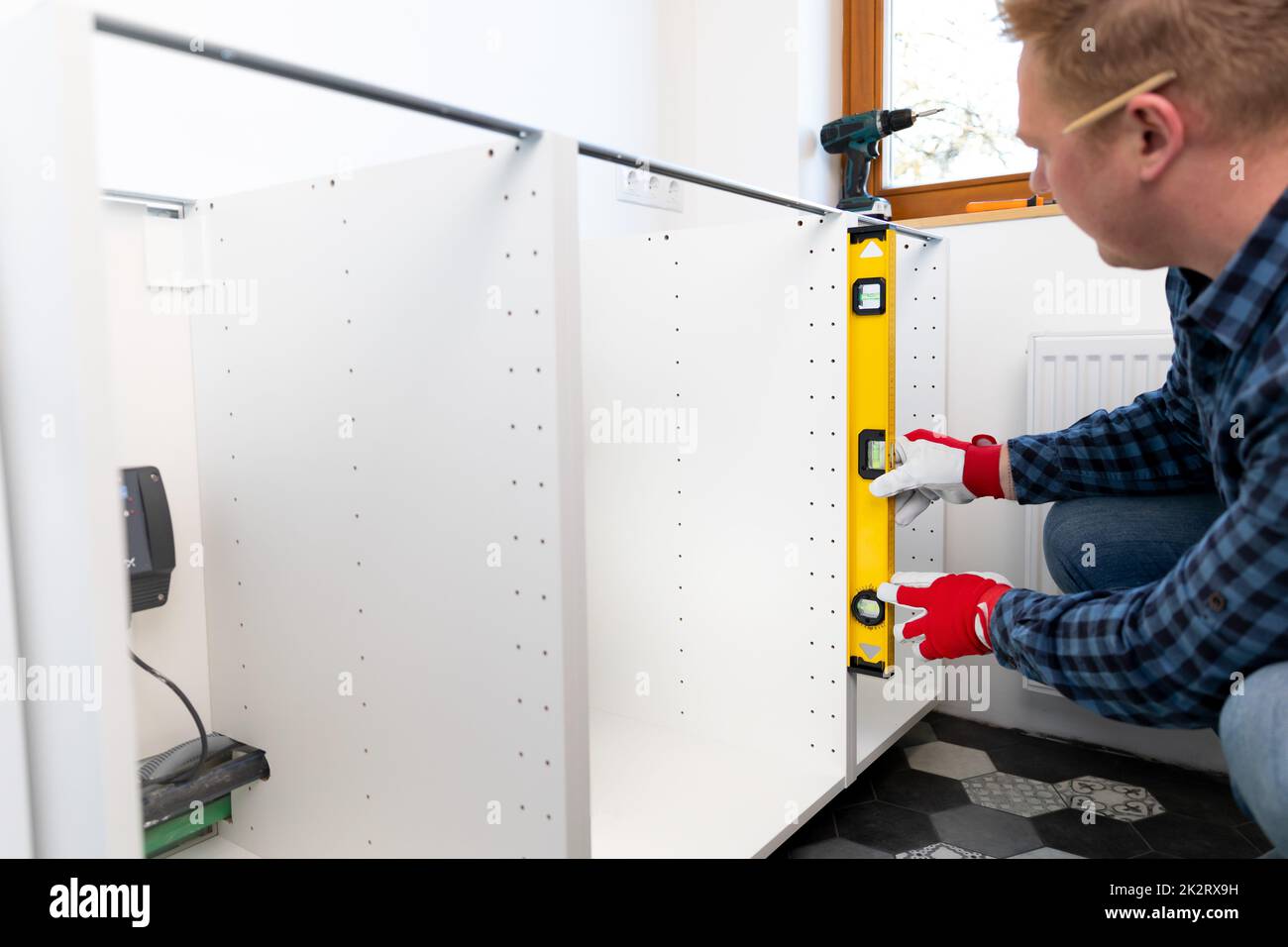 Home improvement. Handyman with leveler install new countertop in newly ...