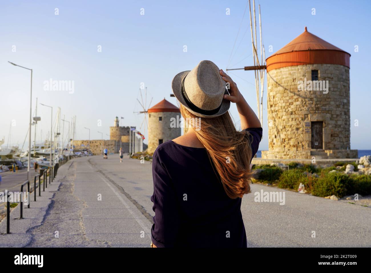 Visiting Rhodes in Greece. Back view of young traveler woman walking ...