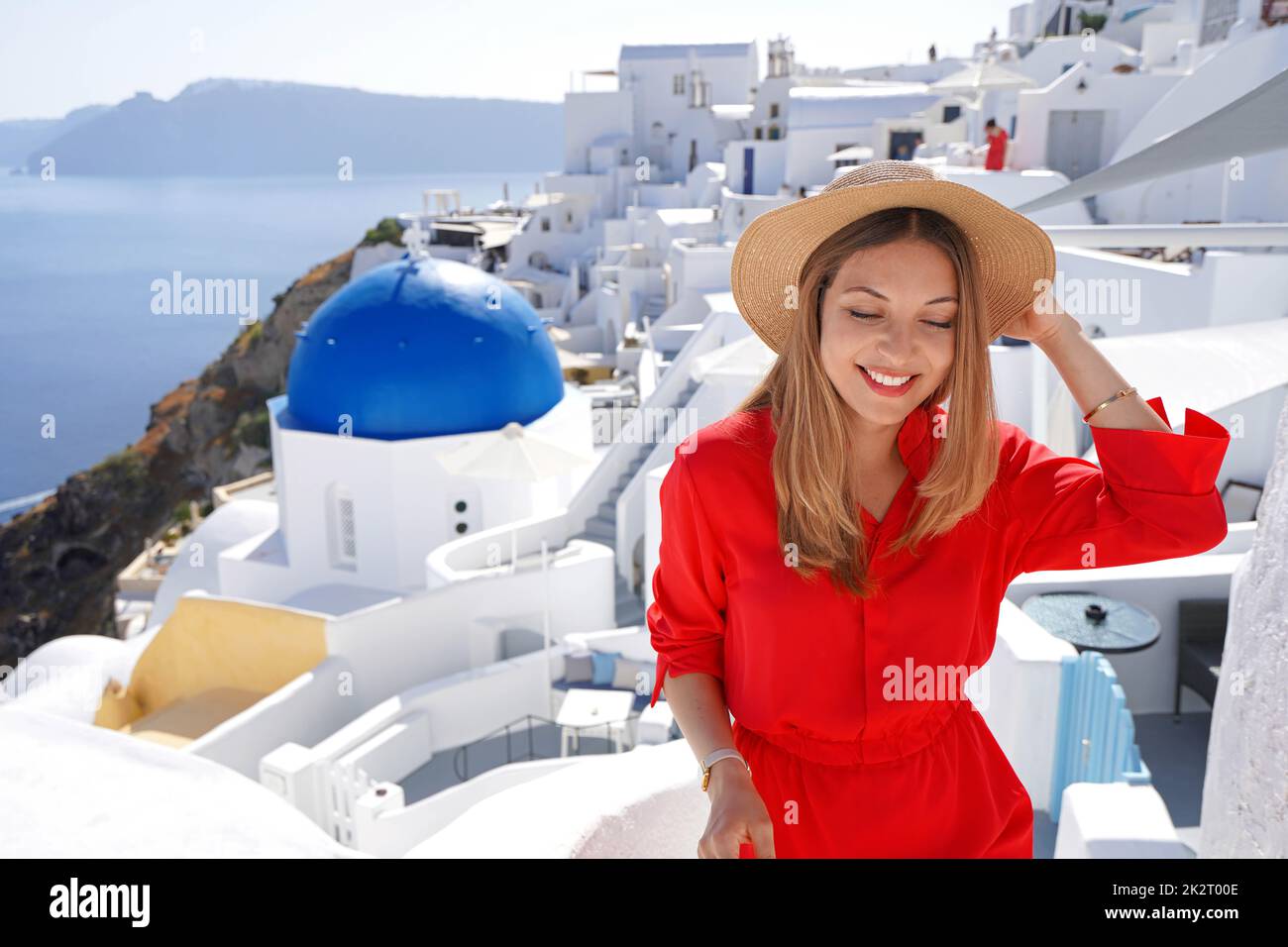 Portrait of fashionable woman in red dress and hat visiting a ...
