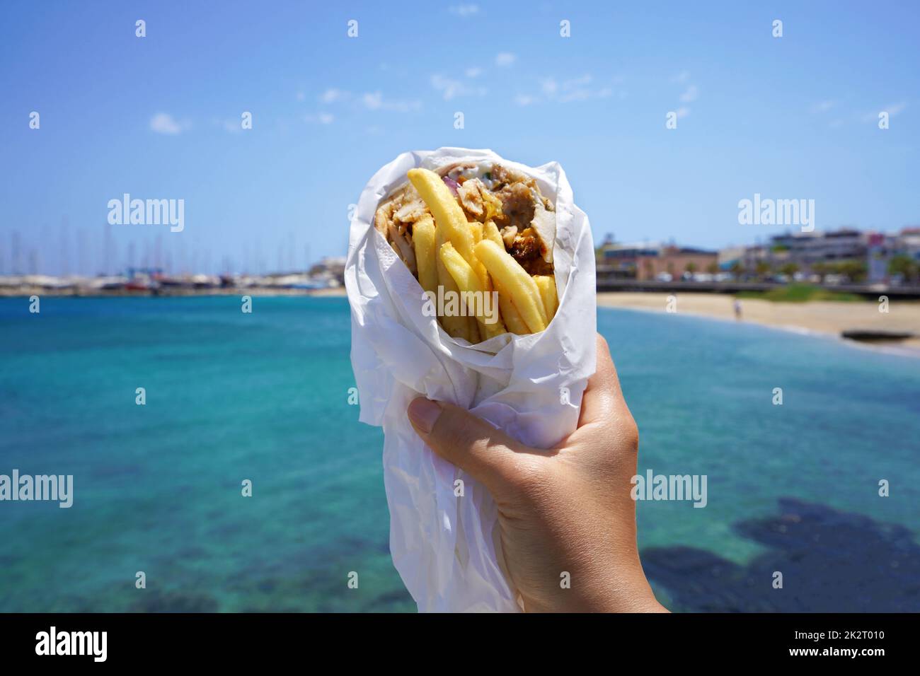 Pita Gyros. Greek gyros wrapped in pita breads against Greek beach with ...