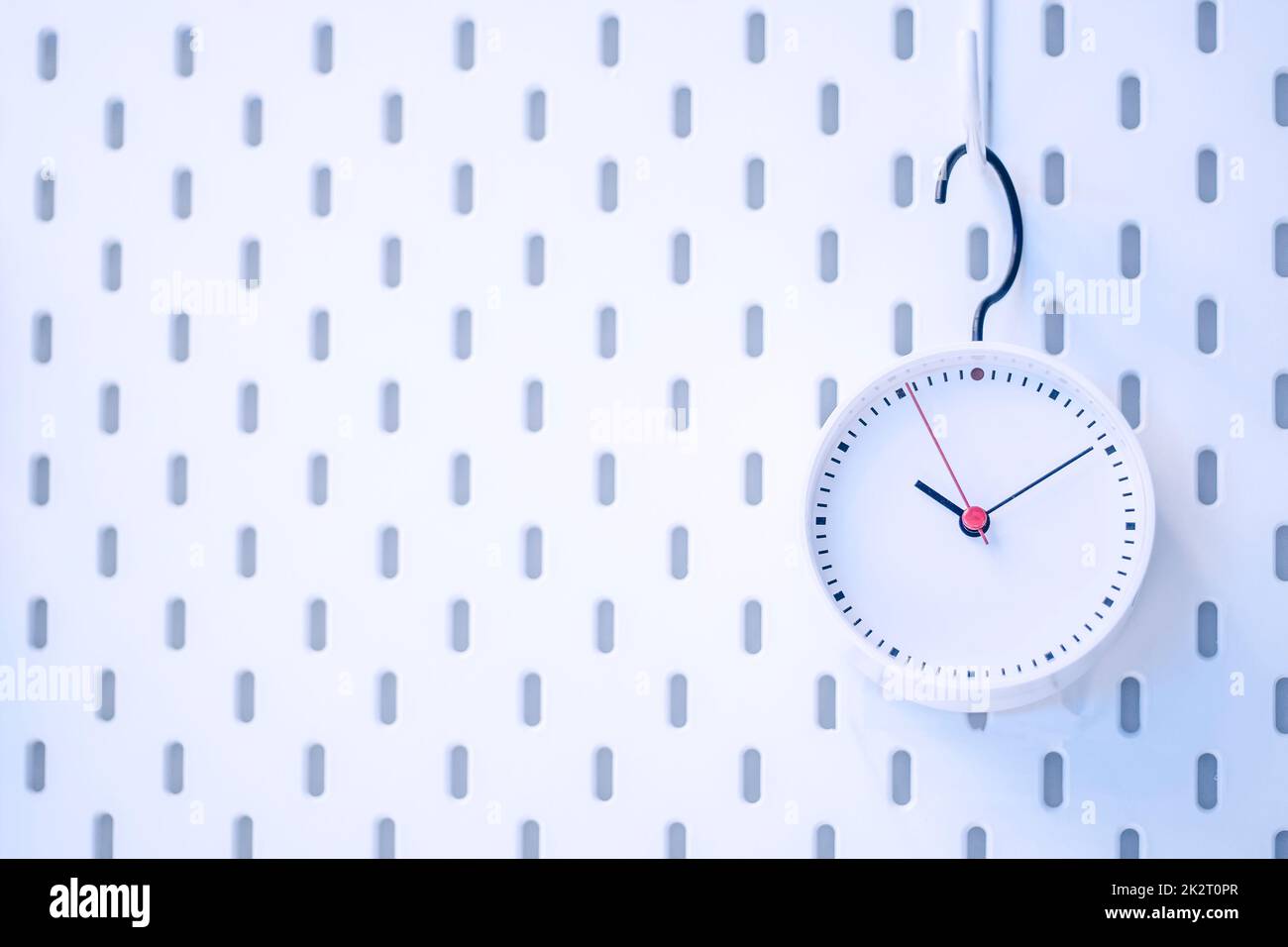 Closeup blue wall clock set on blue background Stock Photo - Alamy