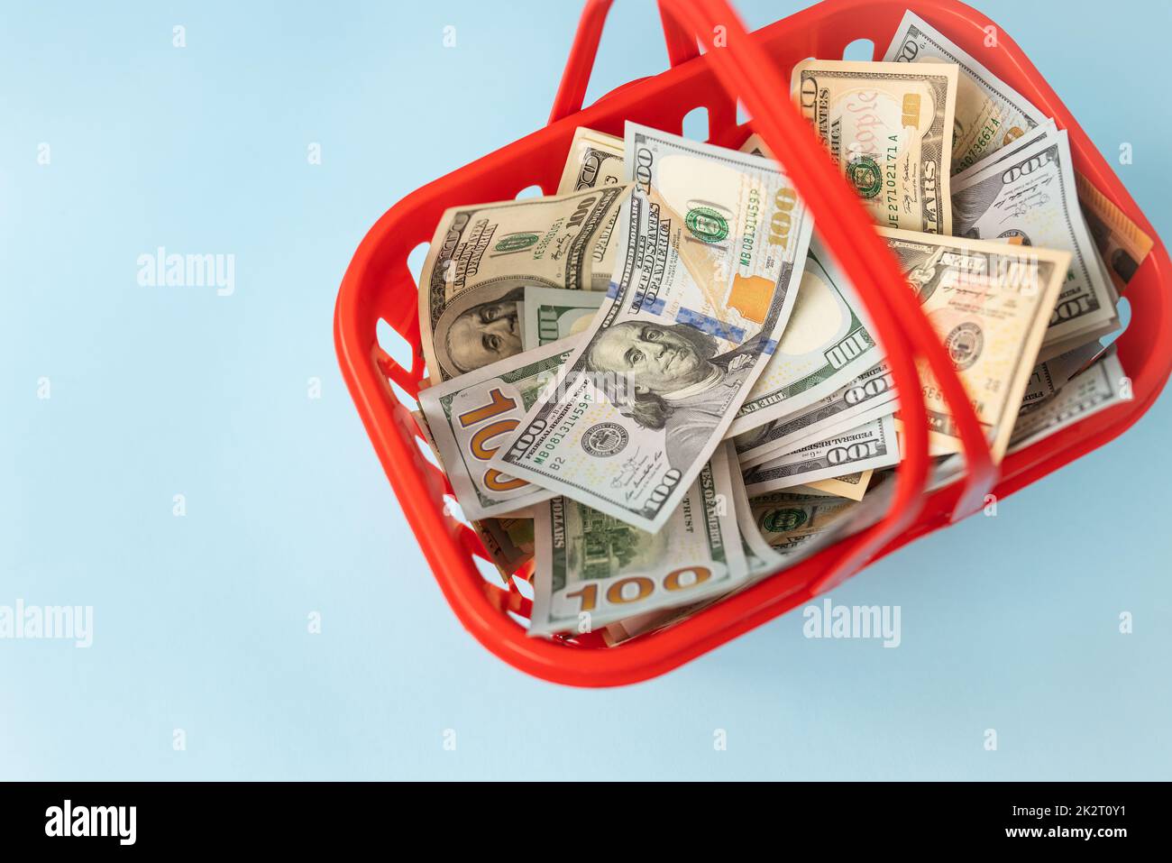 Red grocery cart with many 100 dollar bills inside. The concept of ...