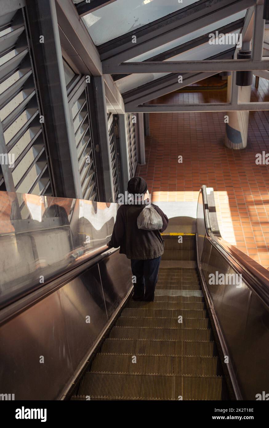 A vertical shot of human standing on escalator in metro station Stock ...