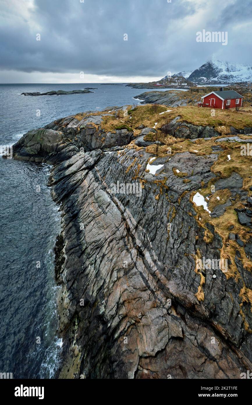 Clif with traditional red rorbu house on Lofoten Islands, Norway Stock ...
