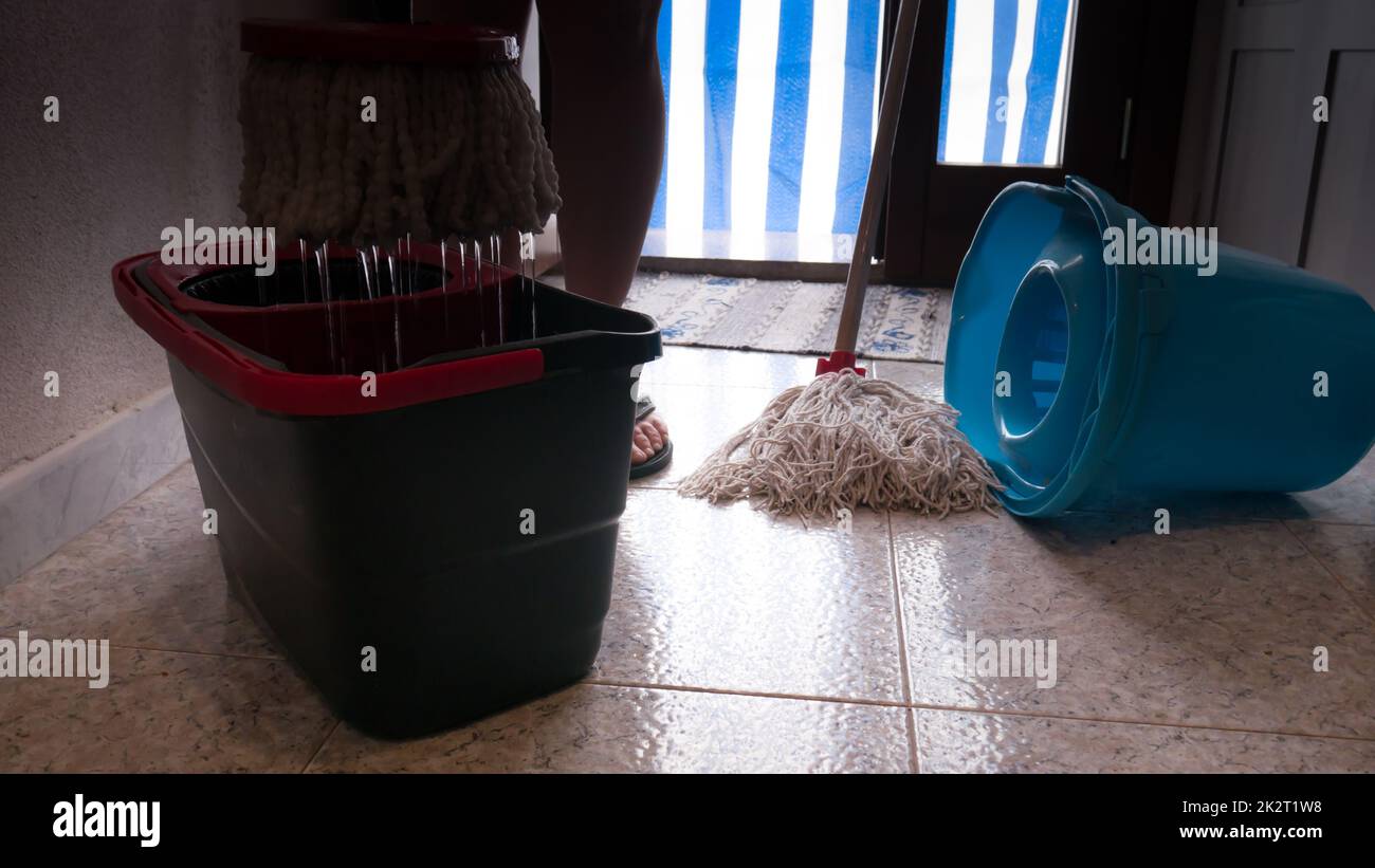 mop wring into the bucket, ready to clean the floor with tiles and ...