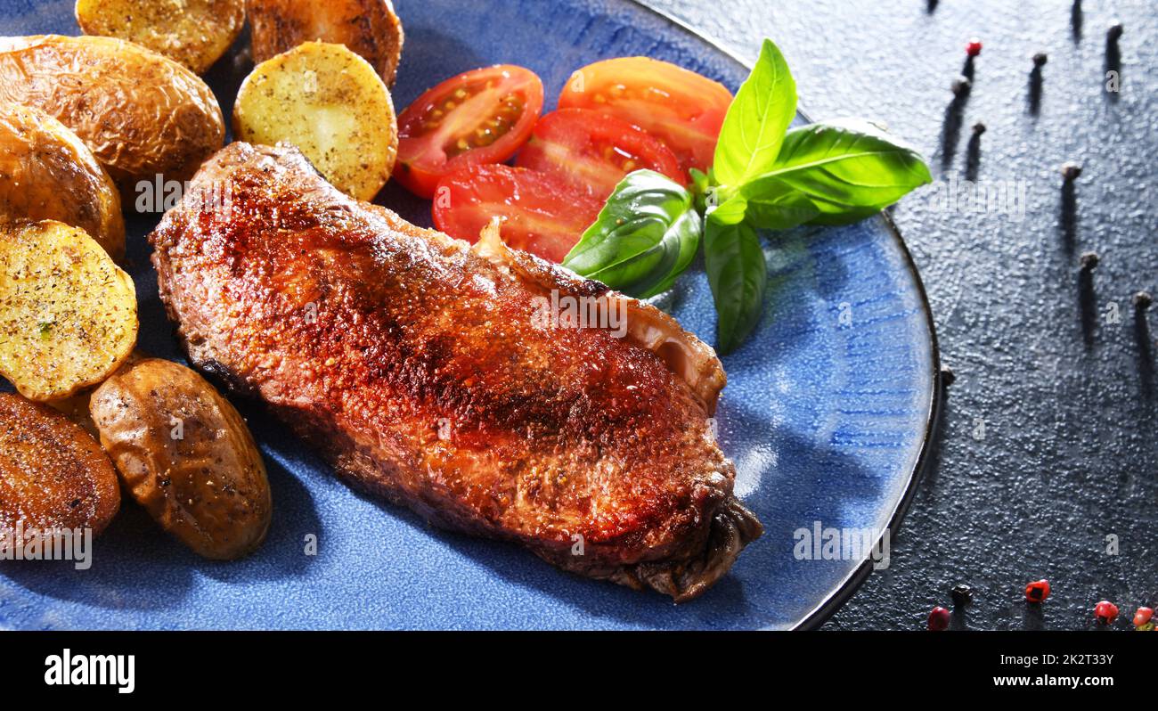 Pan-fried beef steak with fried potatoes and cherry tomatoes Stock ...