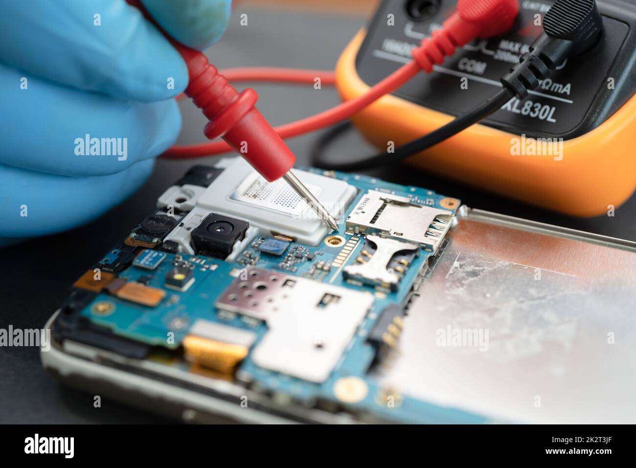 Technician repairing inside of mobile phone by soldering iron ...