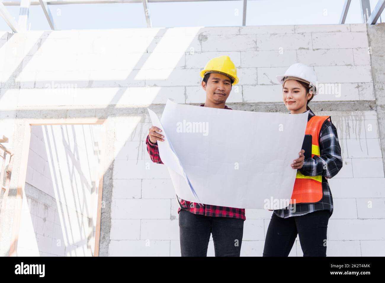 Architect and client discussing the plan with blueprint of the building ...