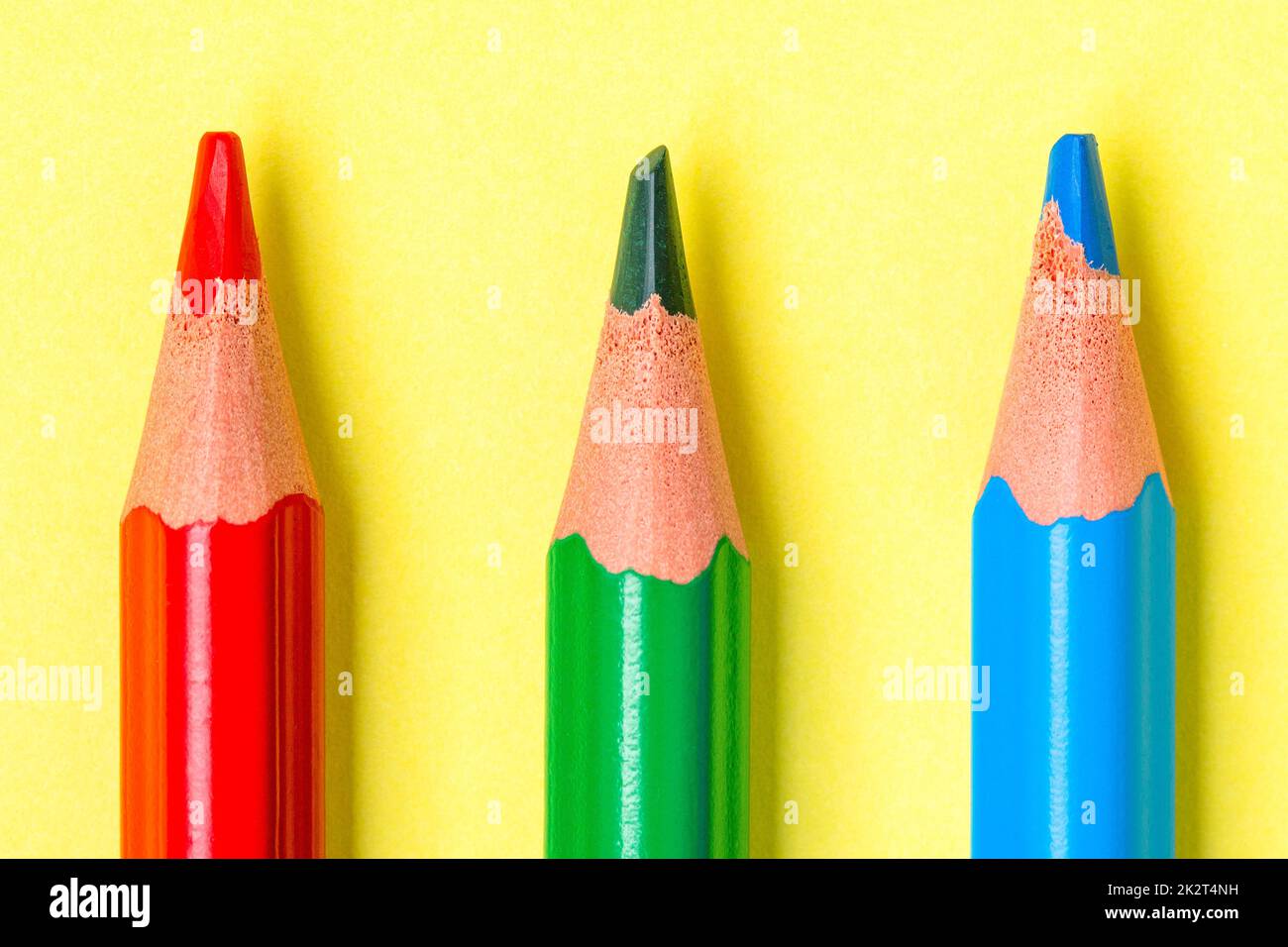 Red, green and blue pencils on a yellow background Stock Photo - Alamy