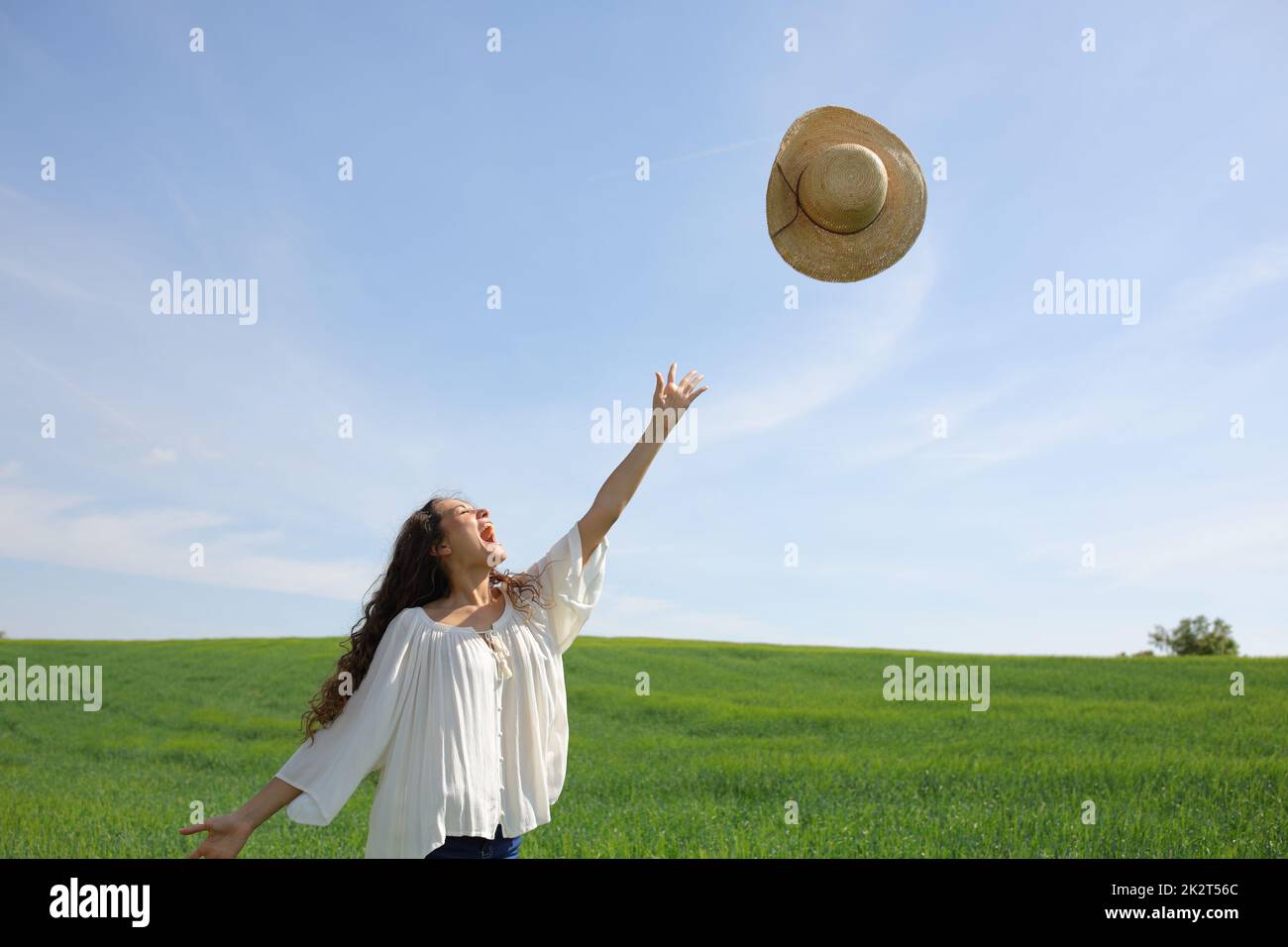 Happy woman throwing pamela to the air in a field Stock Photo - Alamy