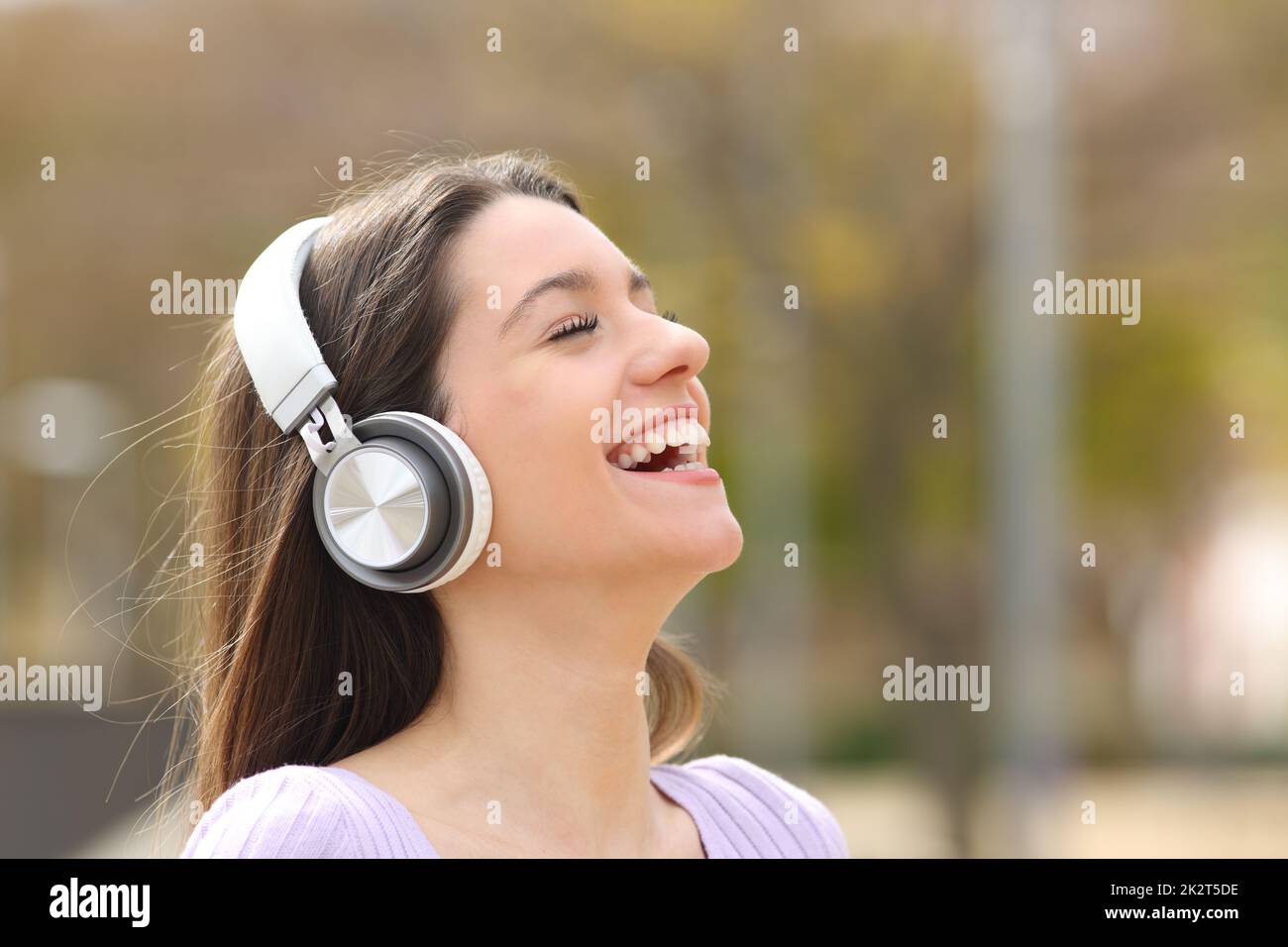Happy teen listening to music laughing in a park Stock Photo - Alamy