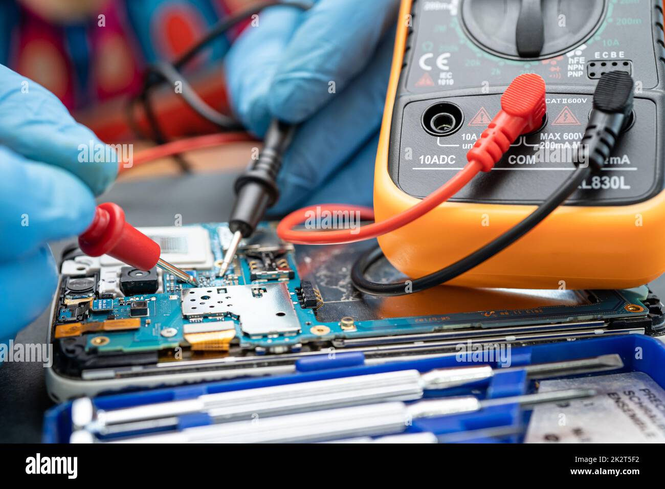 Technician repairing inside of mobile phone by soldering iron ...