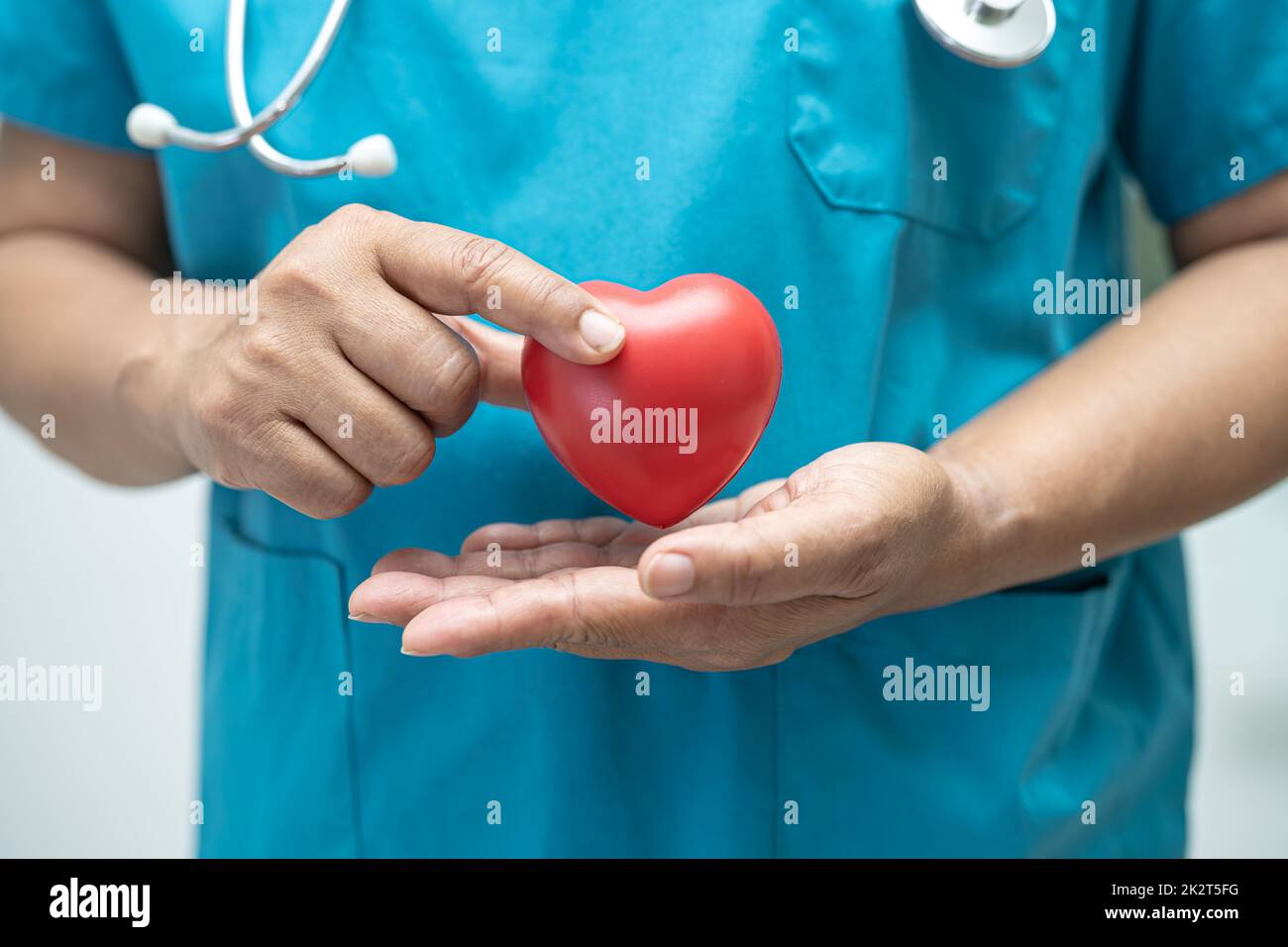 Doctor holding a red heart in hospital ward, healthy strong medical ...