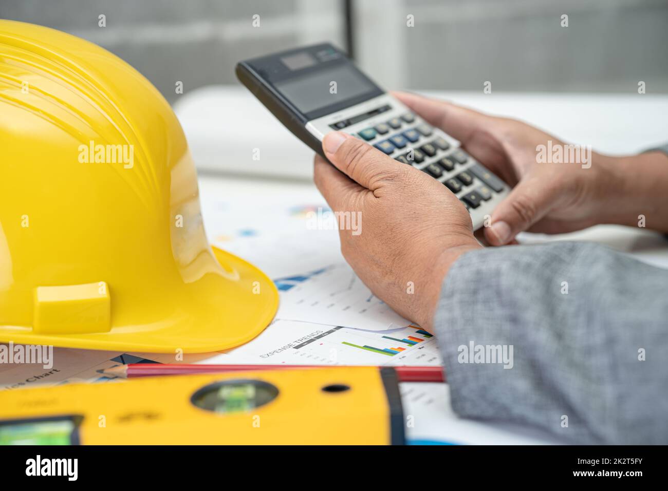 Asian engineer with architectural house plan project blueprint, graph ...