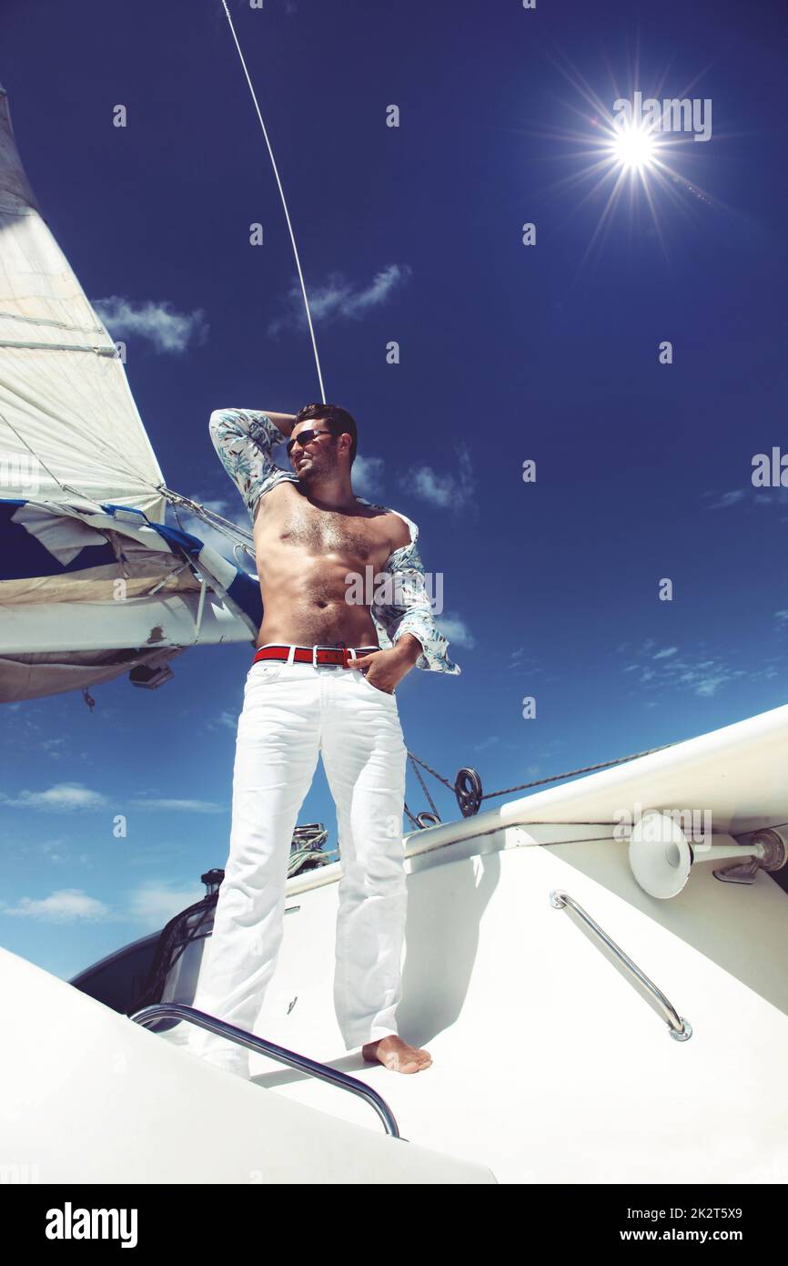 Young man sailing his boat on the open ocean Stock Photo - Alamy