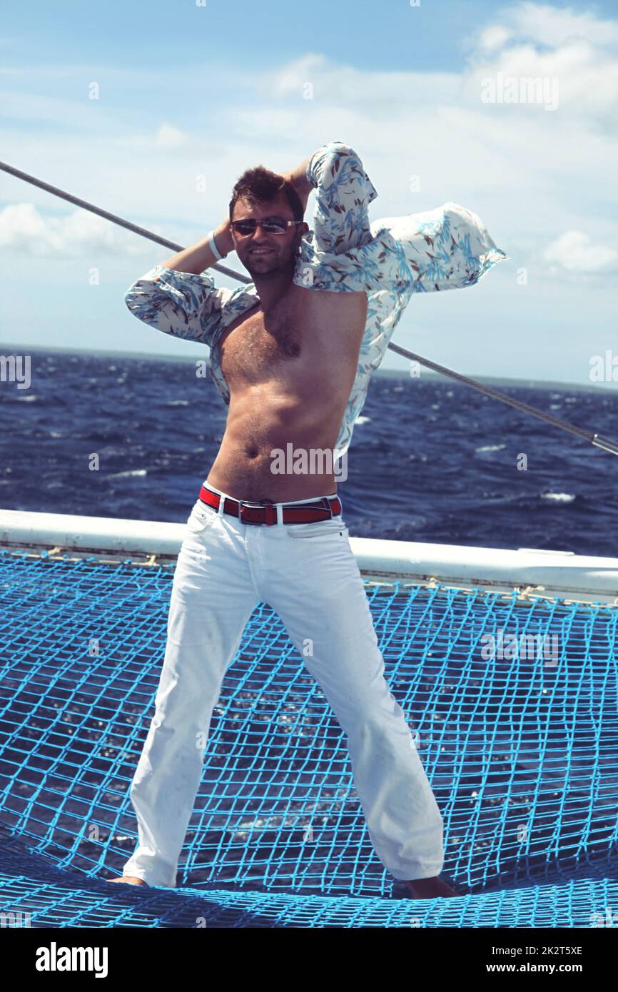 Young man sailing his boat on the open ocean Stock Photo - Alamy