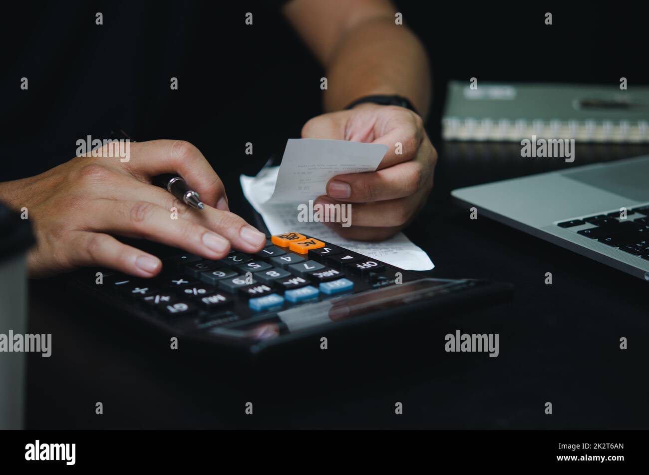 Man hand holding pen and calculator expense or tax receipt. business ...