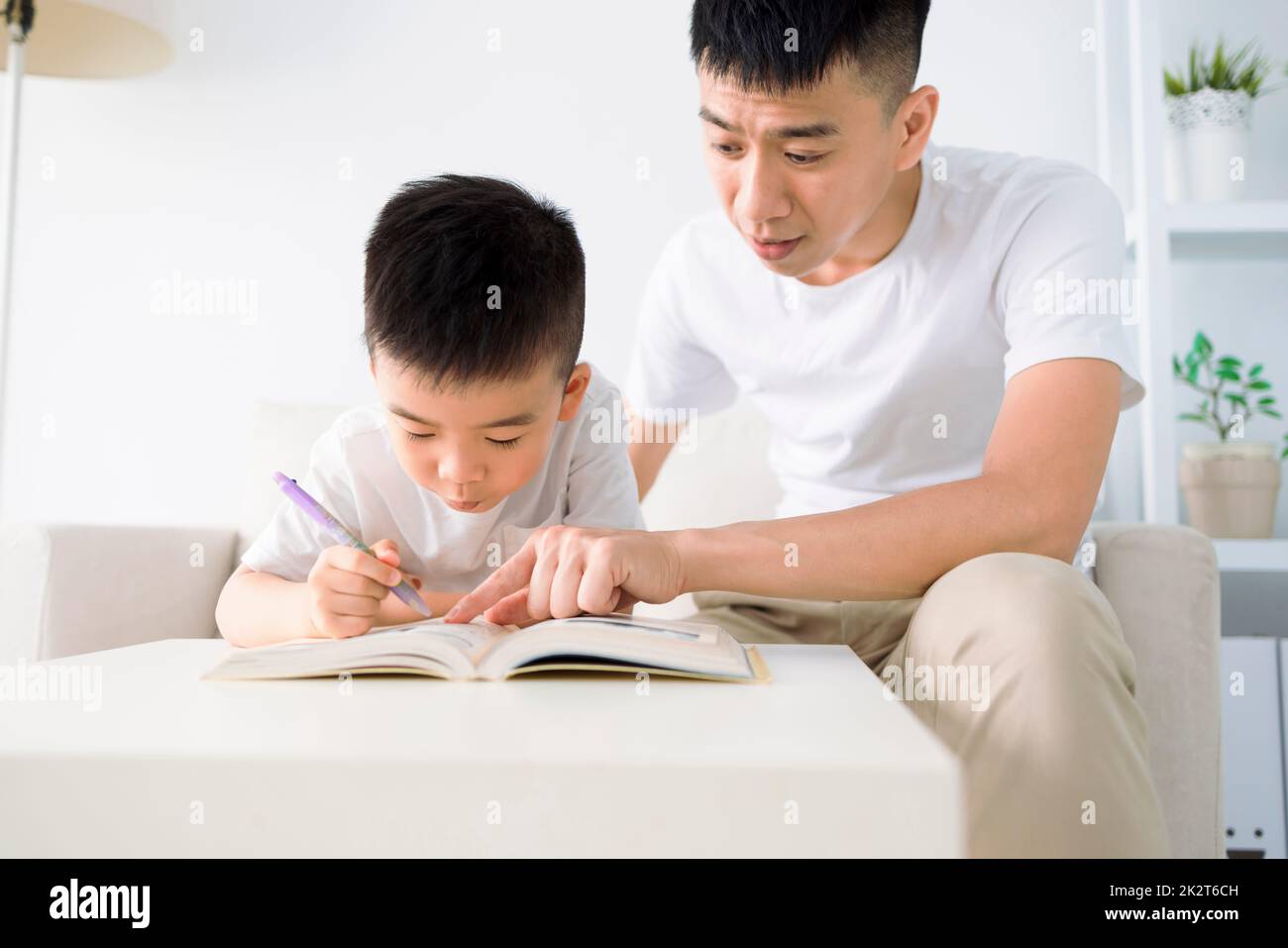 Father helping child doing homework at home Stock Photo - Alamy