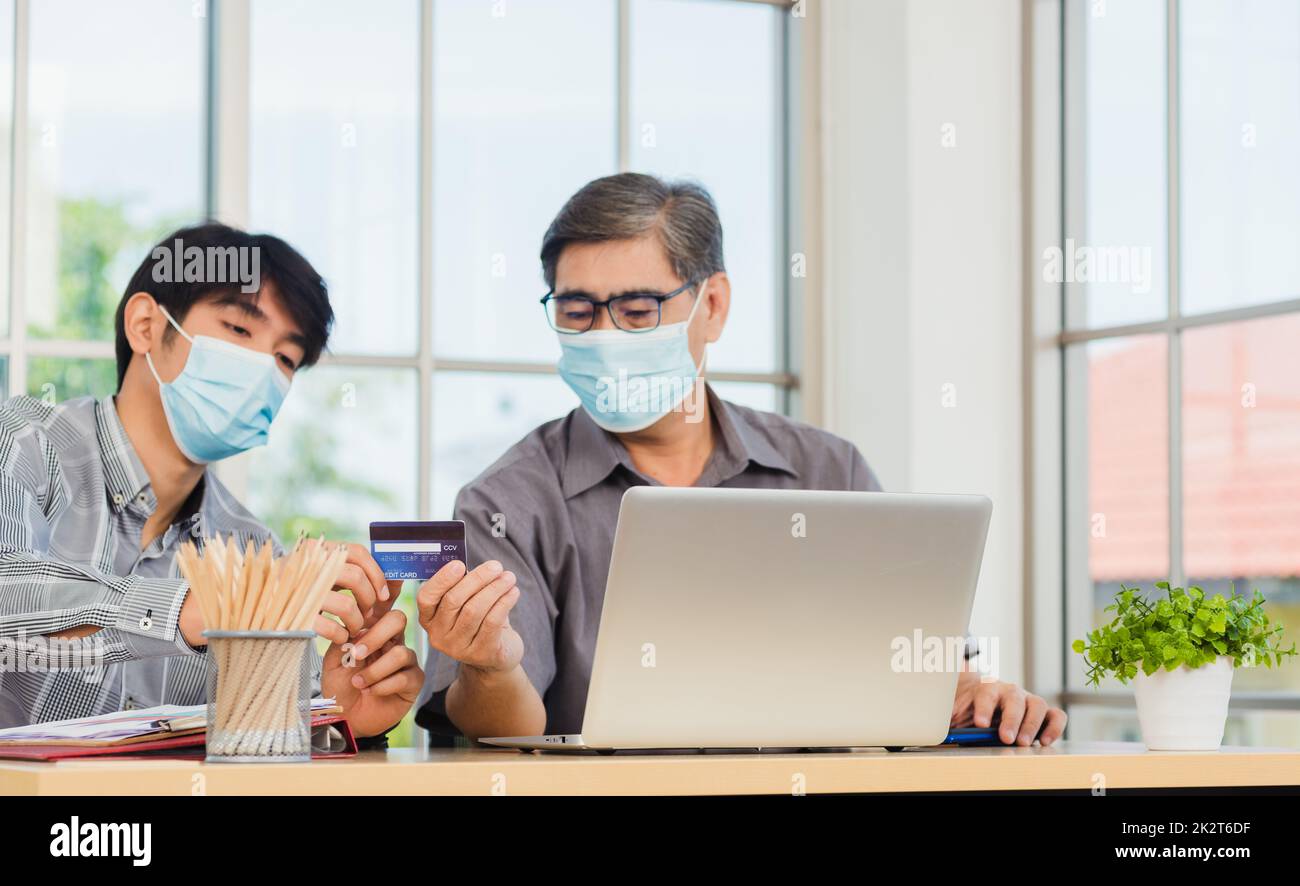 young man teaching senior father how to use credit card for shopping ...