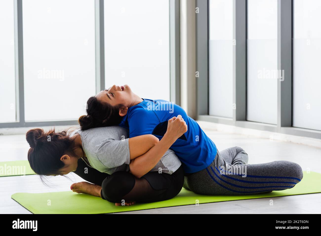 Two Asian women sporty attractive people practicing yoga lesson ...