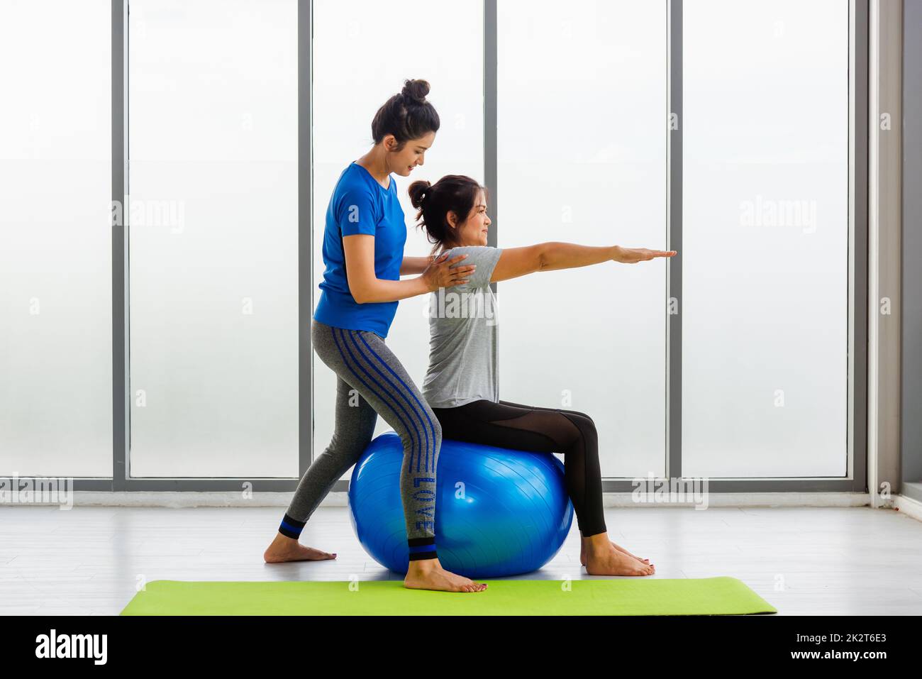 adult and young woman in sportswear doing aerobics yoga exercise with ...