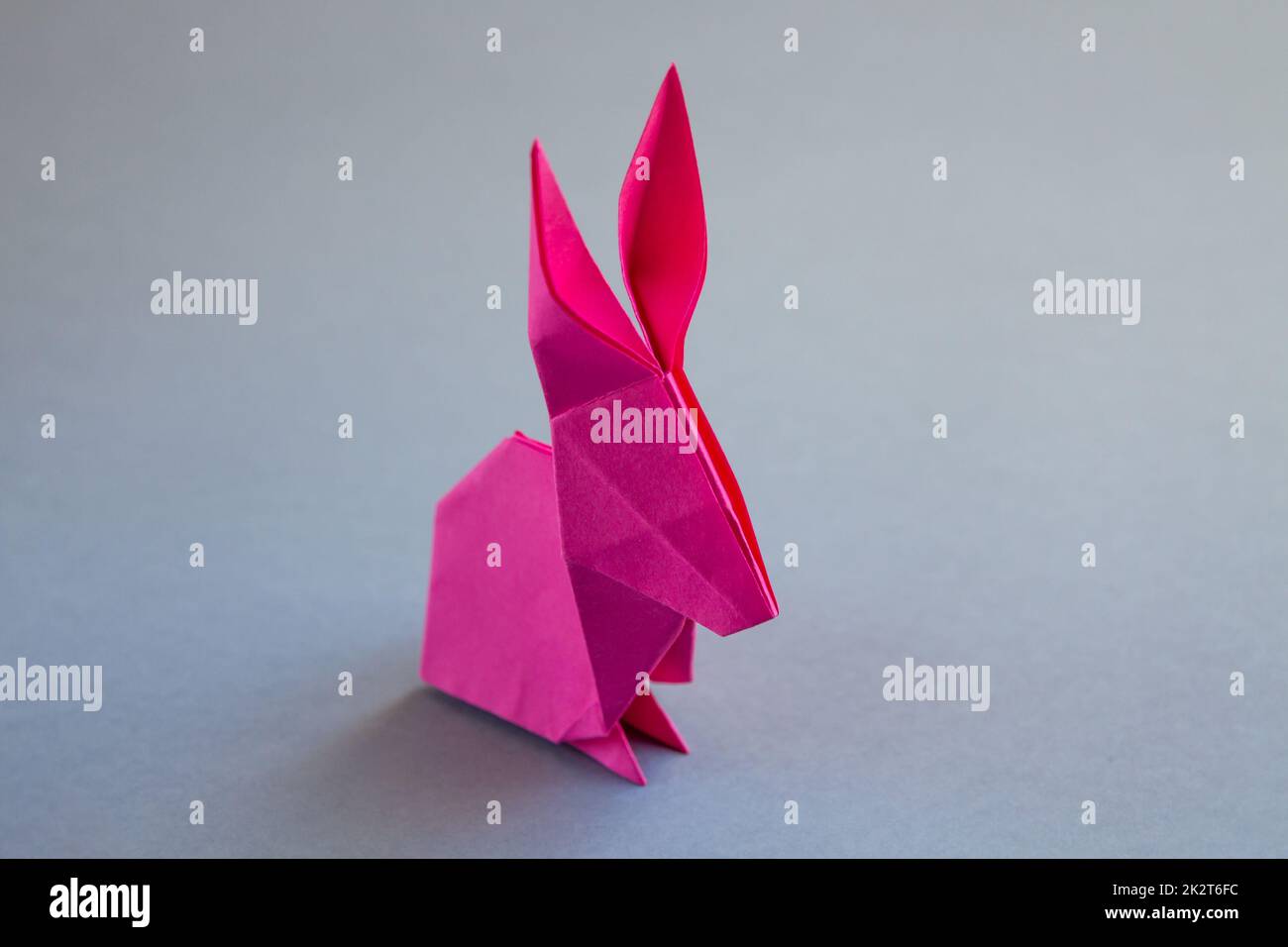 Pink paper rabbit origami isolated on a grey background Stock Photo - Alamy